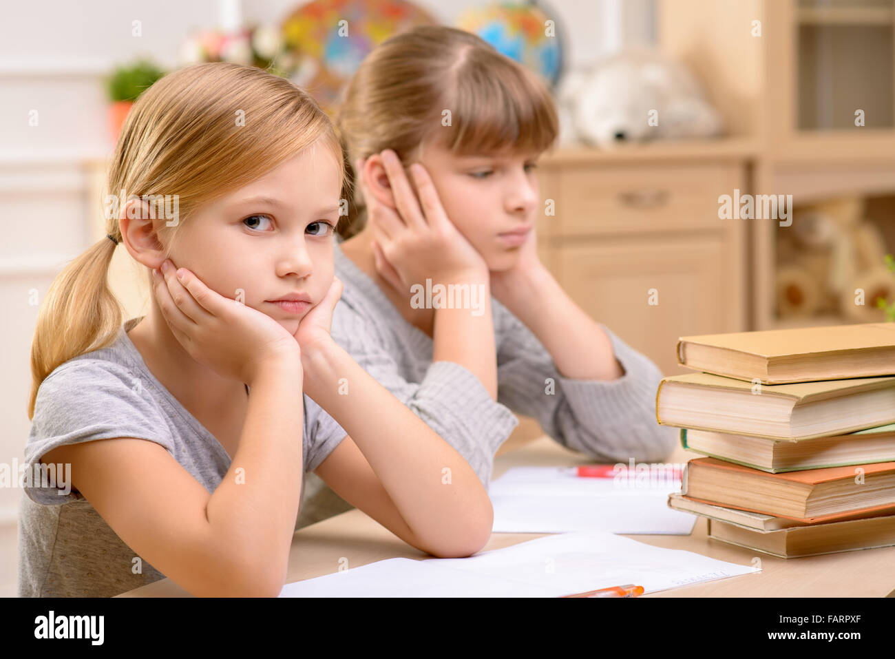 Pretty little girls sitting at the table Stock Photo - Alamy