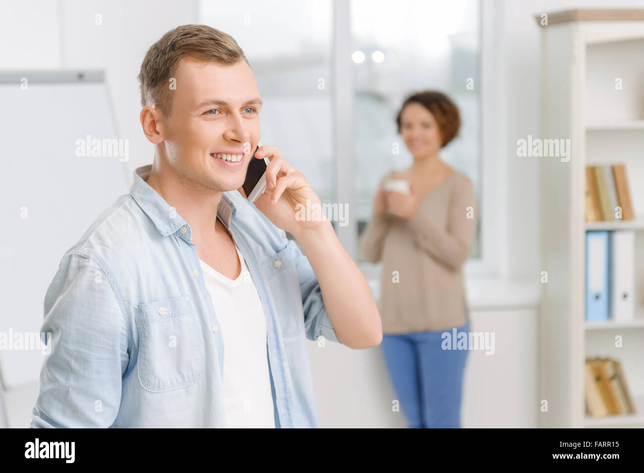 Young office worker is making a phone call Stock Photo - Alamy