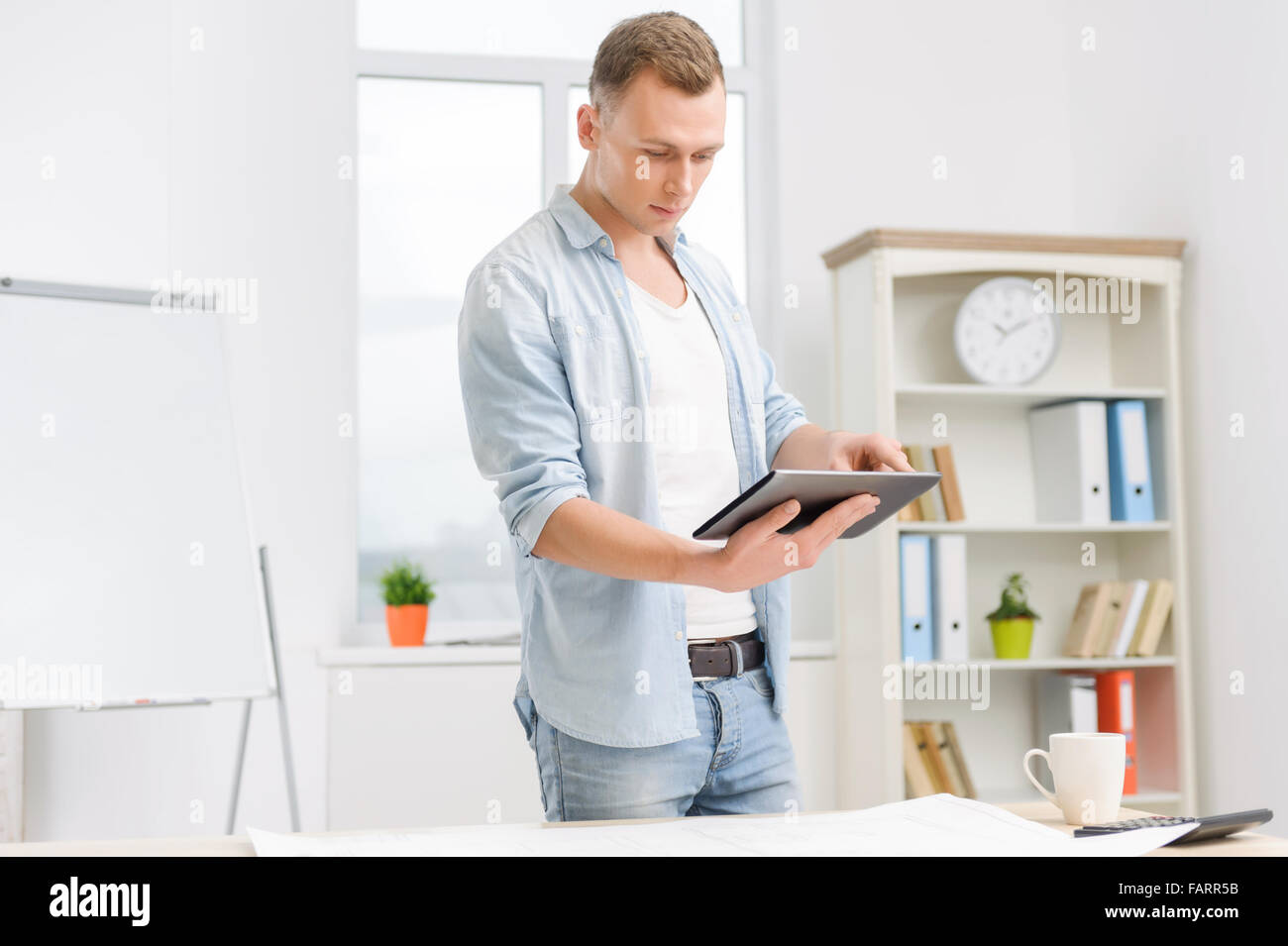 Male employee is working on the tablet Stock Photo - Alamy