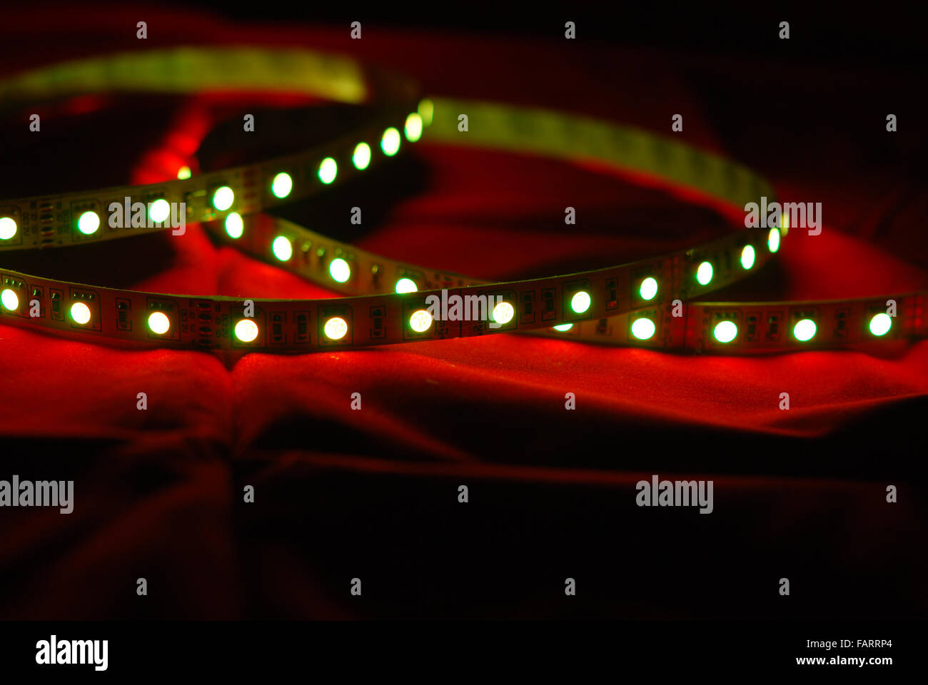 Green led strip on the background of red textile Stock Photo - Alamy