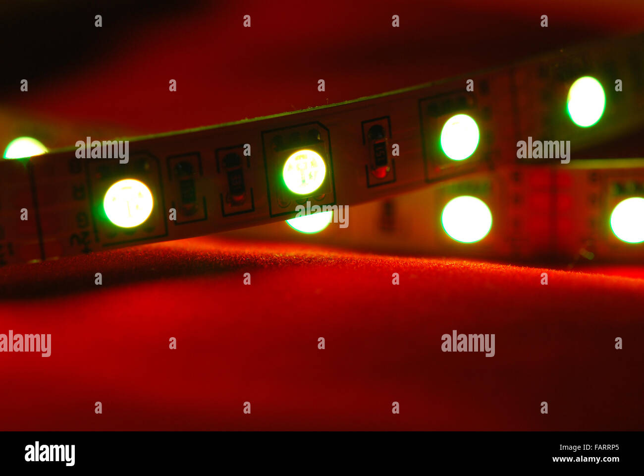 Green led strip on the background of red textile Stock Photo - Alamy