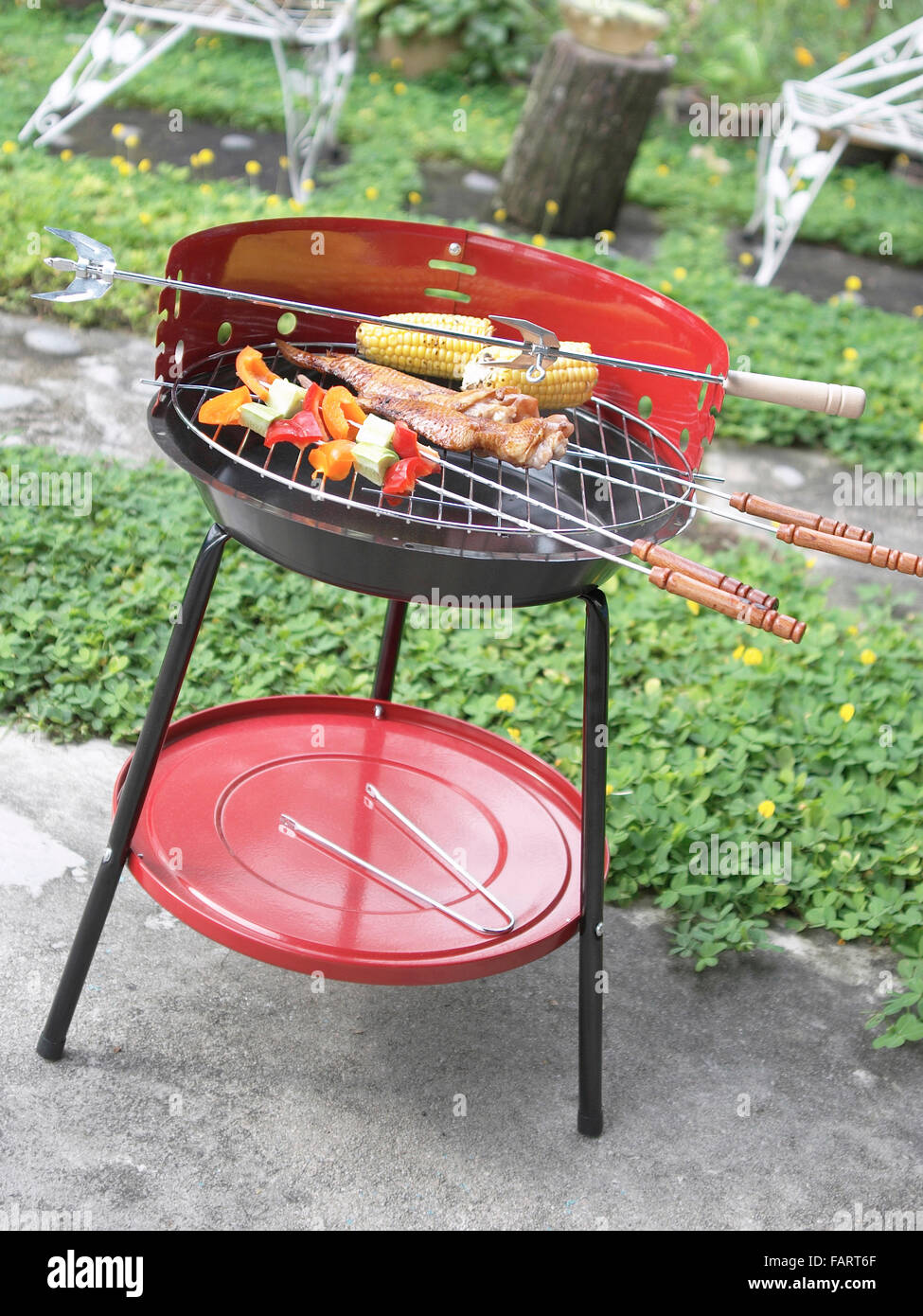 A red barbecue grill with foods for grilling Stock Photo - Alamy