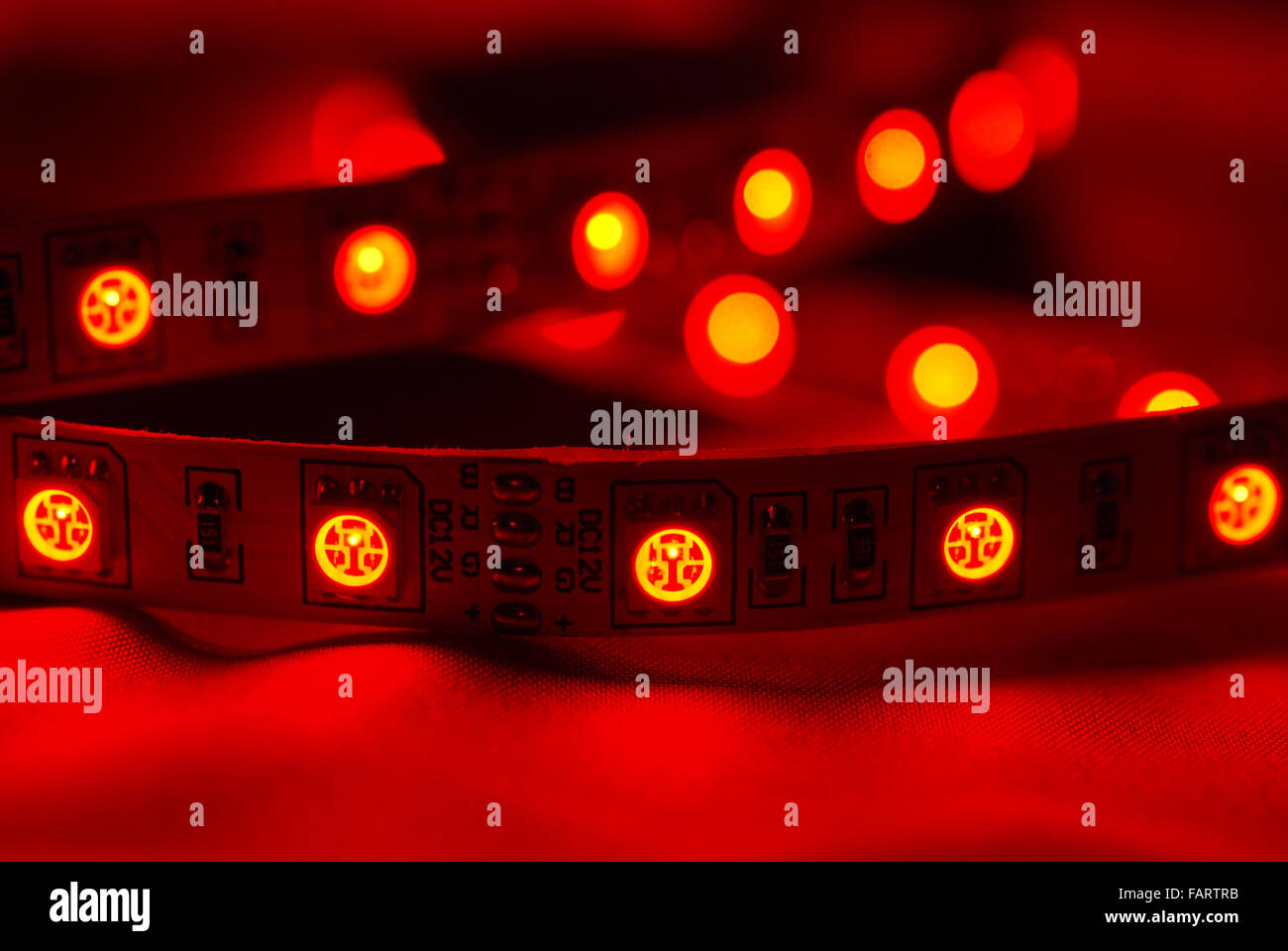 red led strip on the background of red textile Stock Photo - Alamy