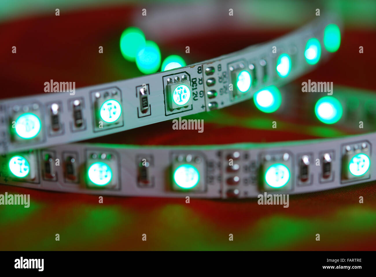 Green led strip on the background of red textile Stock Photo - Alamy