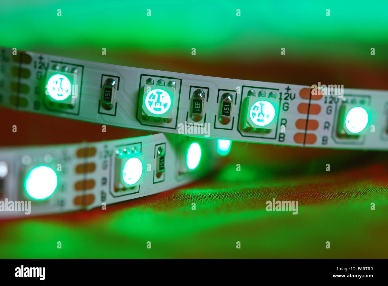 Green led strip on the background of red textile Stock Photo - Alamy