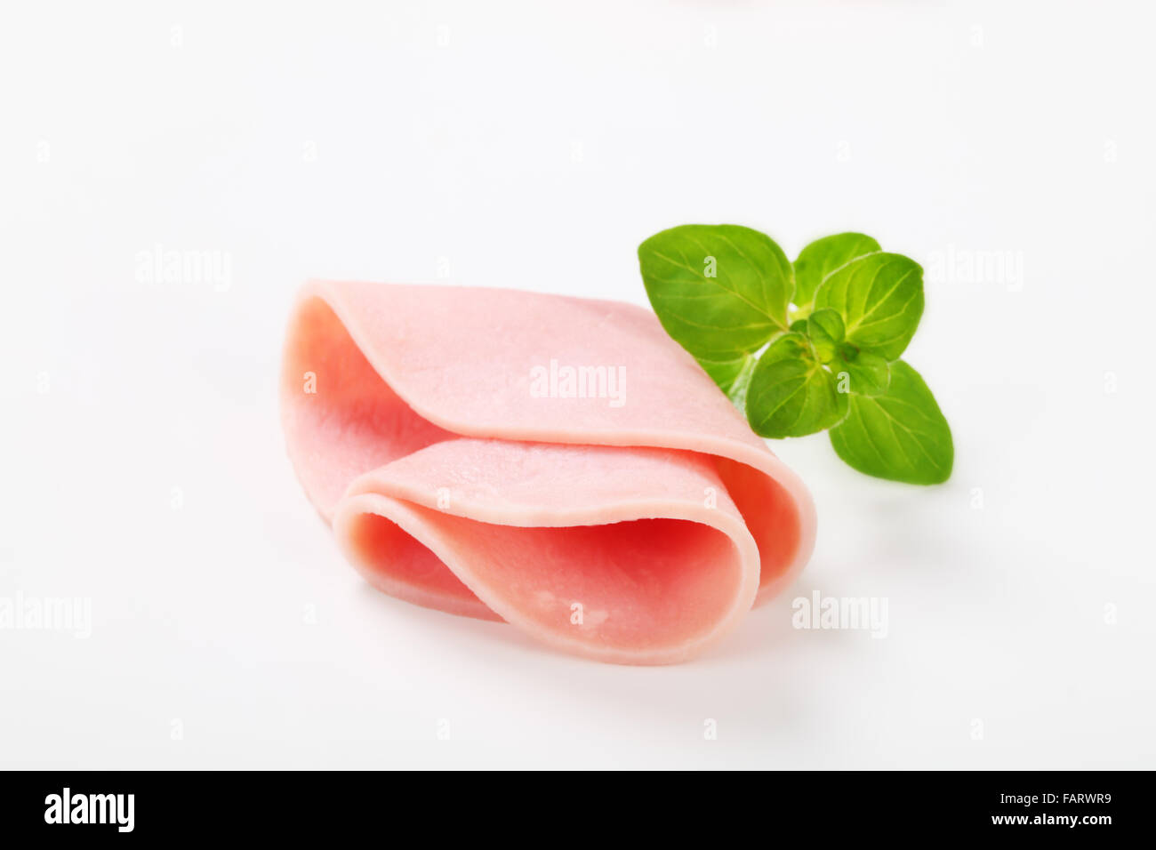 Thin slice of ham on white background Stock Photo - Alamy