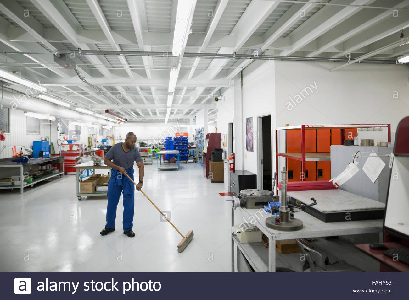 Helicopter mechanic sweeping workshop floor Stock Photo - Alamy