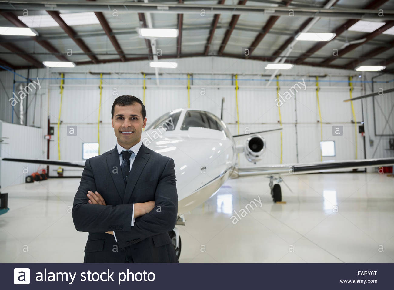 Portrait confident pilot corporate jet airplane hangar Stock Photo - Alamy