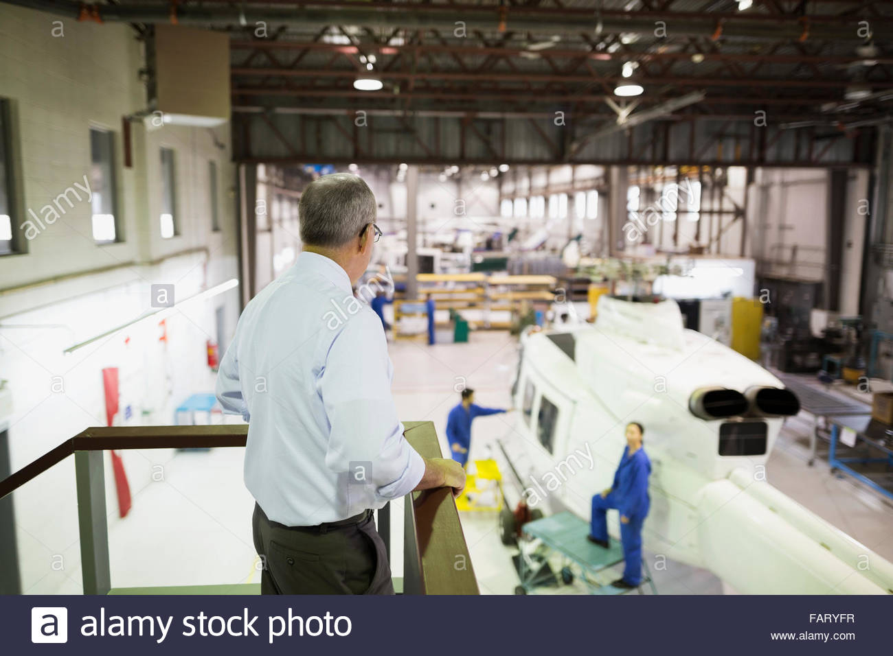 Manager on platform watching helicopter mechanics airplane hangar Stock ...