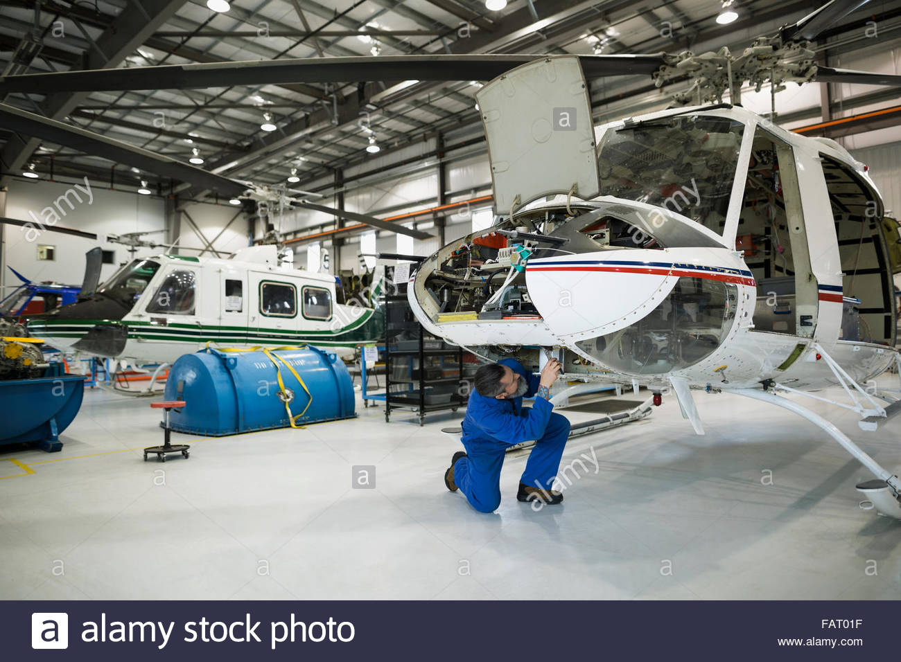 Helicopter mechanic repairing engine in airplane hangar Stock Photo - Alamy