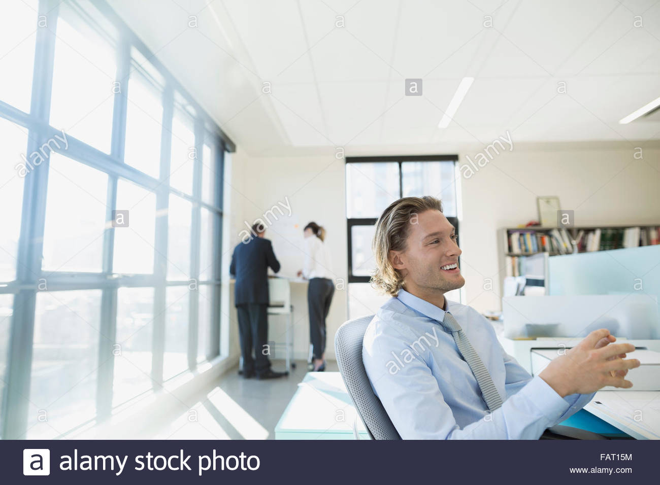 Smiling businessman at desk in office Stock Photo - Alamy