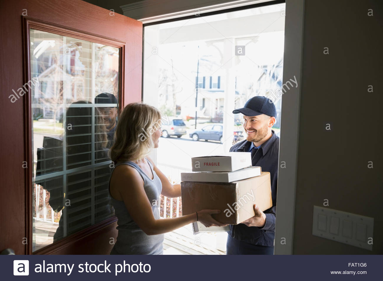 Woman receiving delivery at front door Stock Photo - Alamy