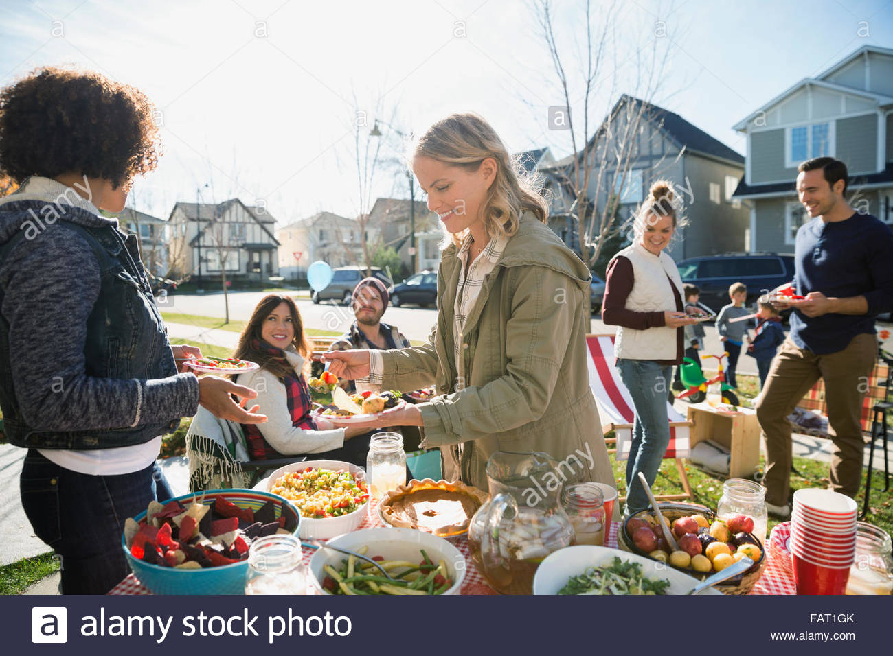 Neighbors enjoying potluck in sunny front yard Stock Photo - Alamy