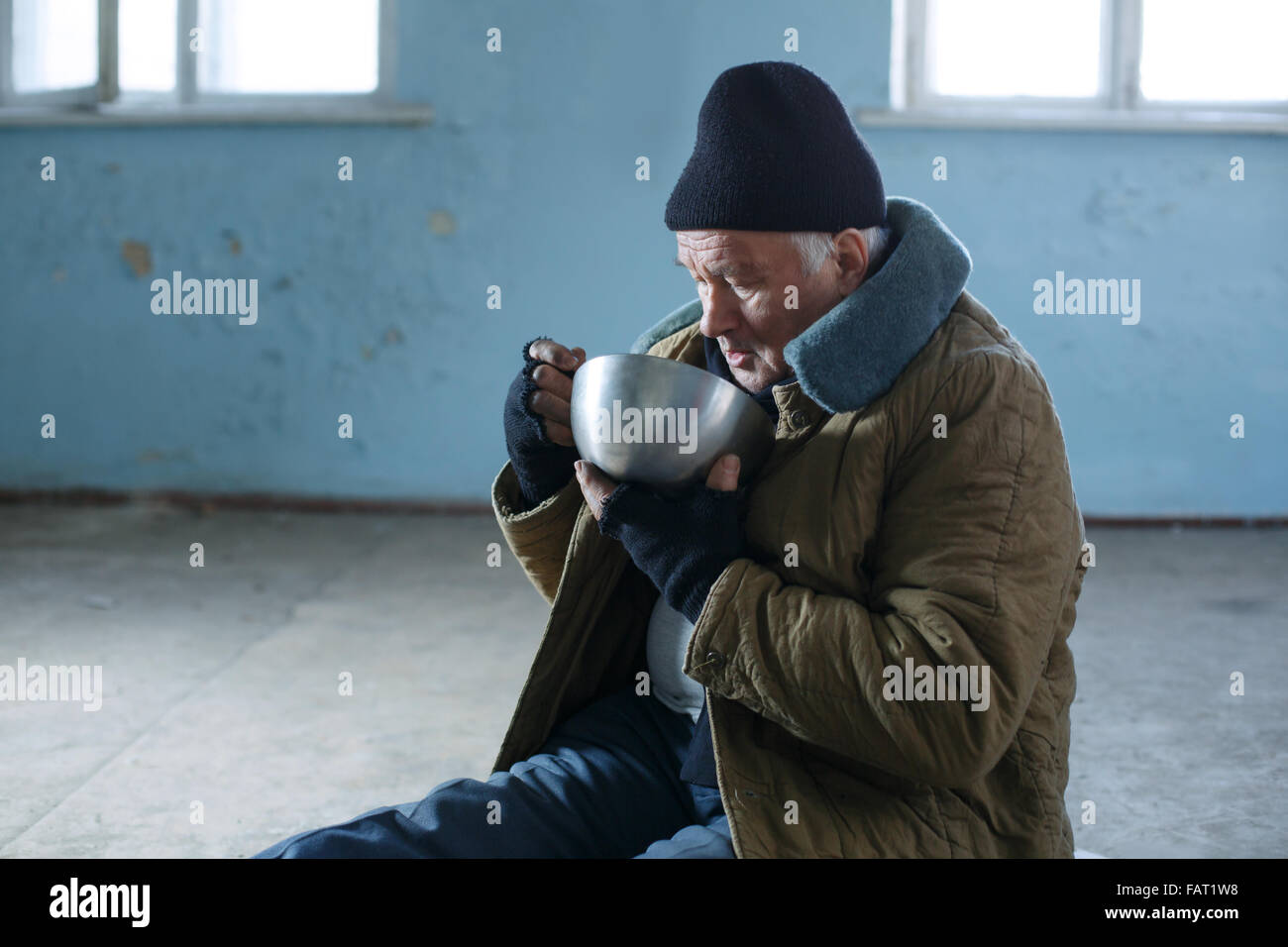 Old-aged bum is eating from his iron bowl Stock Photo - Alamy