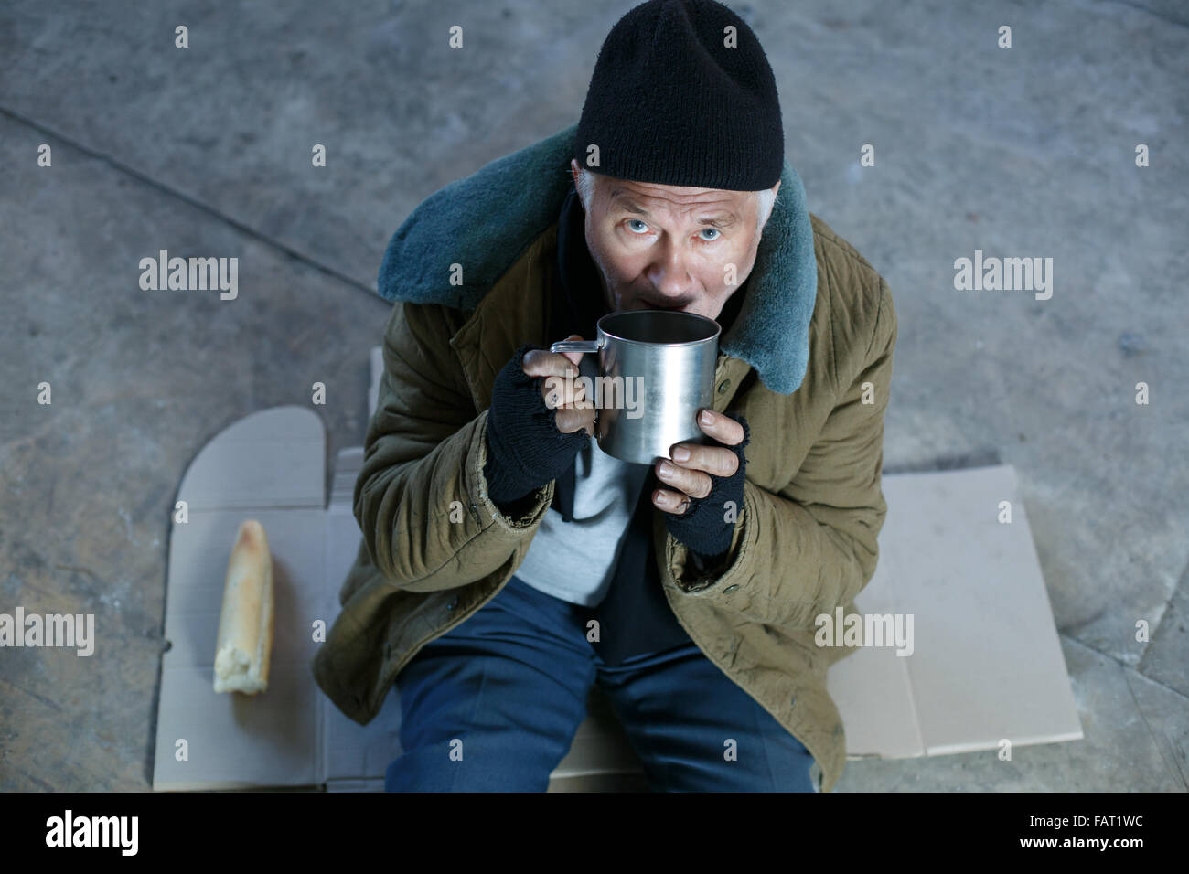 Homeless old man drinking from iron mug Stock Photo - Alamy