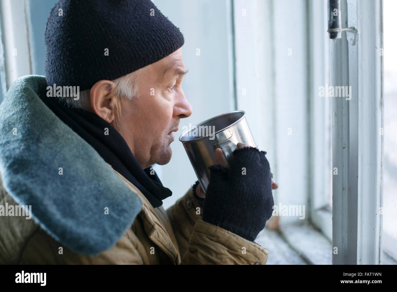 Homeless man holding his iron cup Stock Photo - Alamy