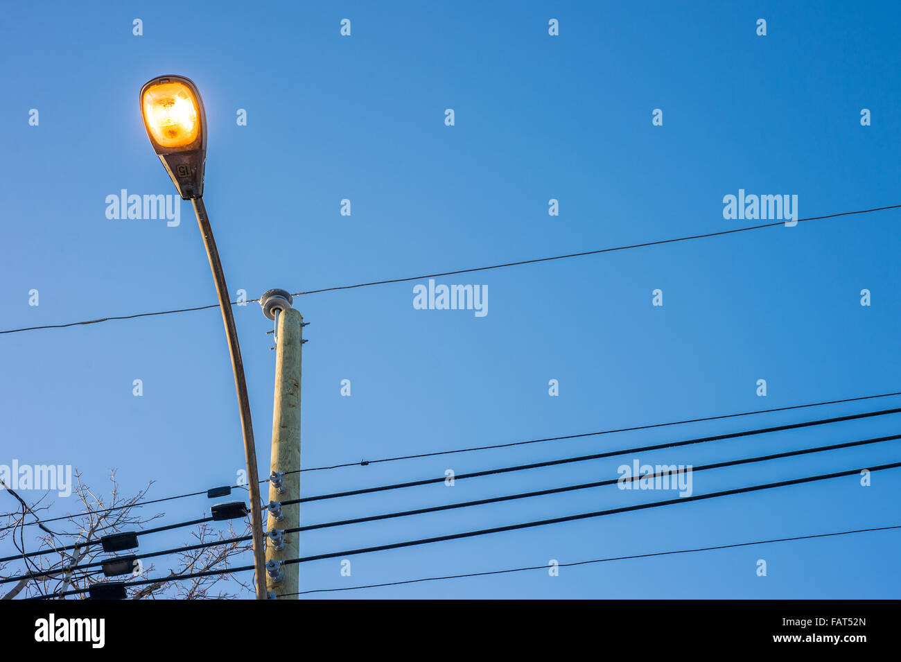 Modern street lights illuminated in Montreal, over blue sky background ...