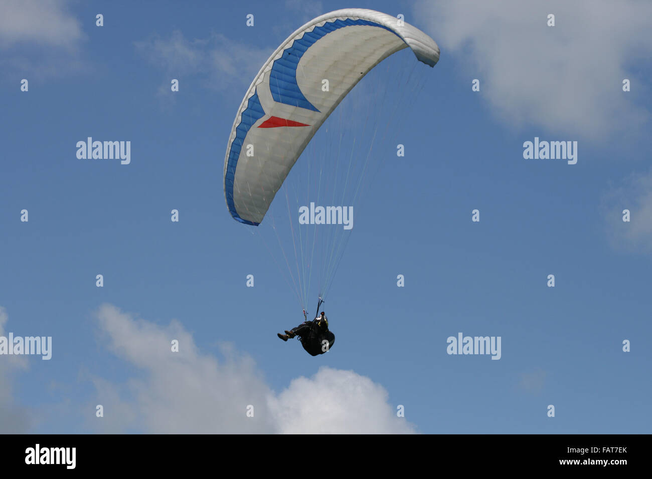 Pilot flying a paraglider against a blue sky perhaps with clouds Stock ...