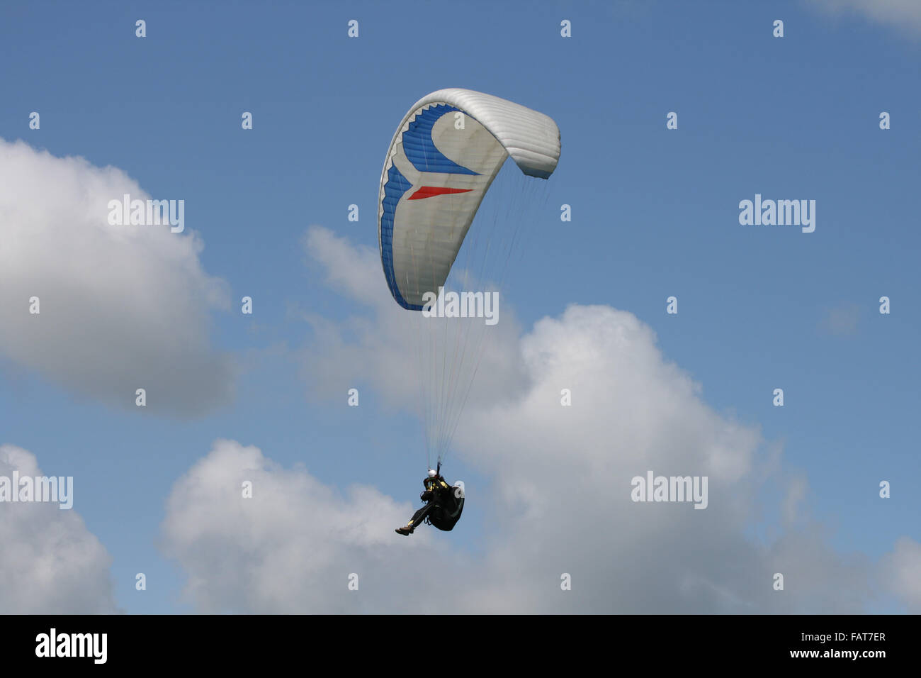 Pilot flying a paraglider against a blue sky perhaps with clouds Stock ...