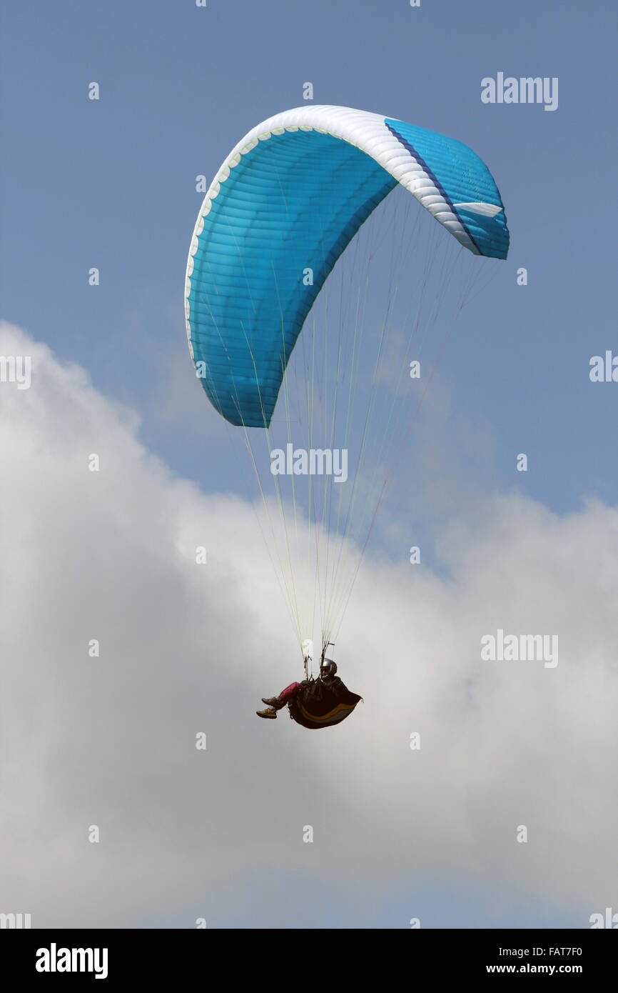 Pilot flying a paraglider against a blue sky perhaps with clouds Stock ...