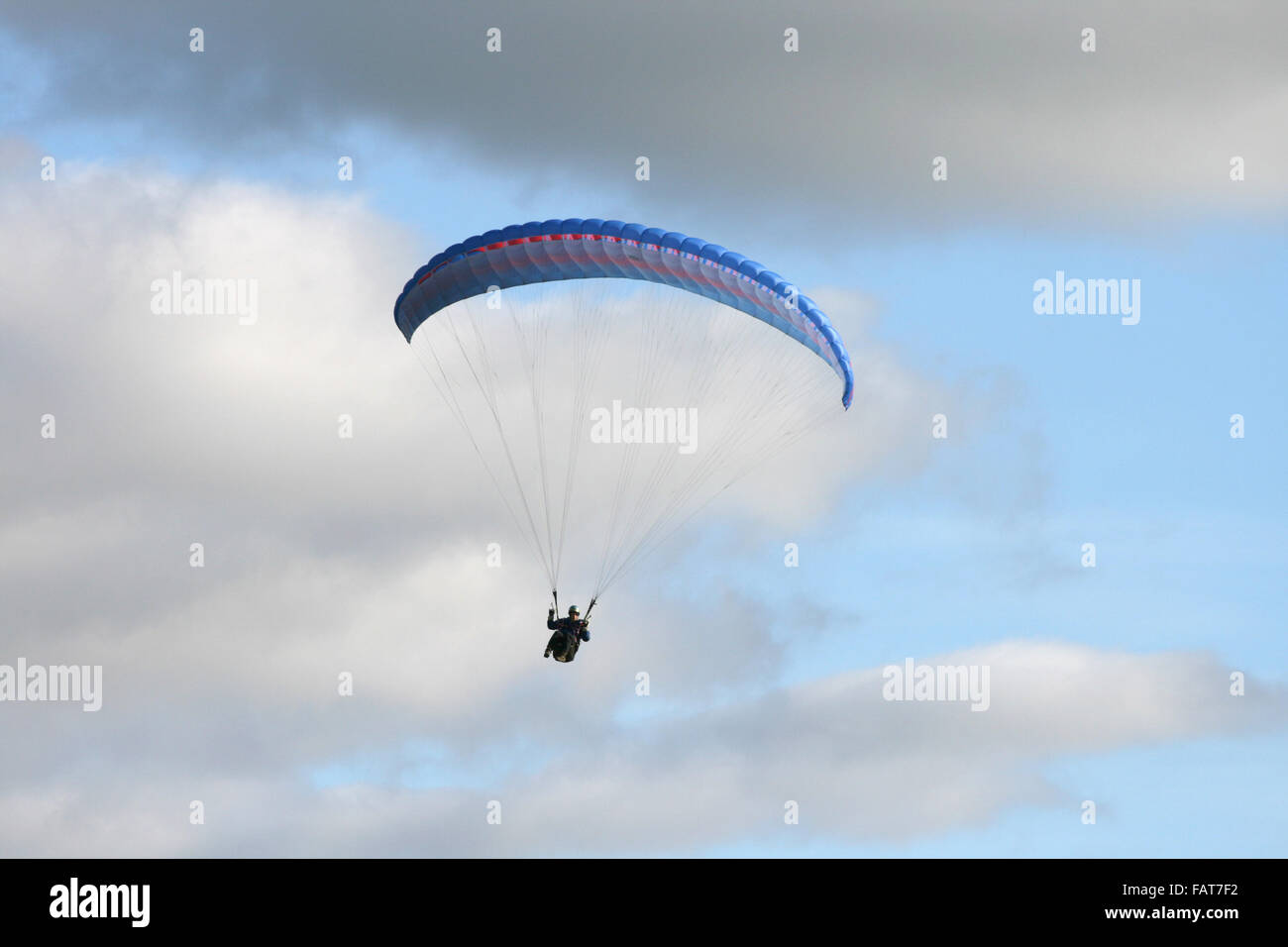 Pilot flying a paraglider against a blue sky perhaps with clouds Stock ...