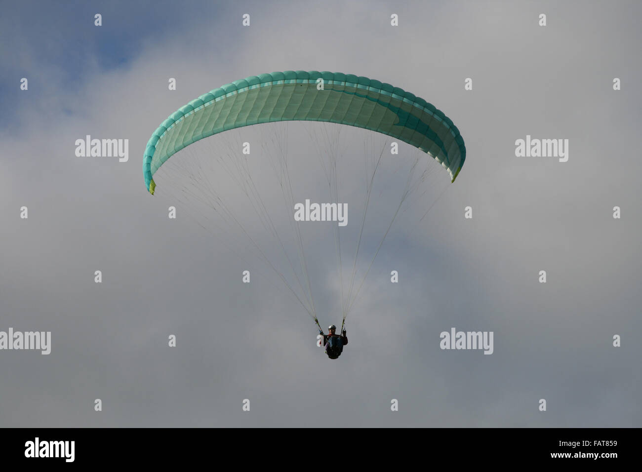 Pilot flying a paraglider against a blue sky perhaps with clouds Stock ...