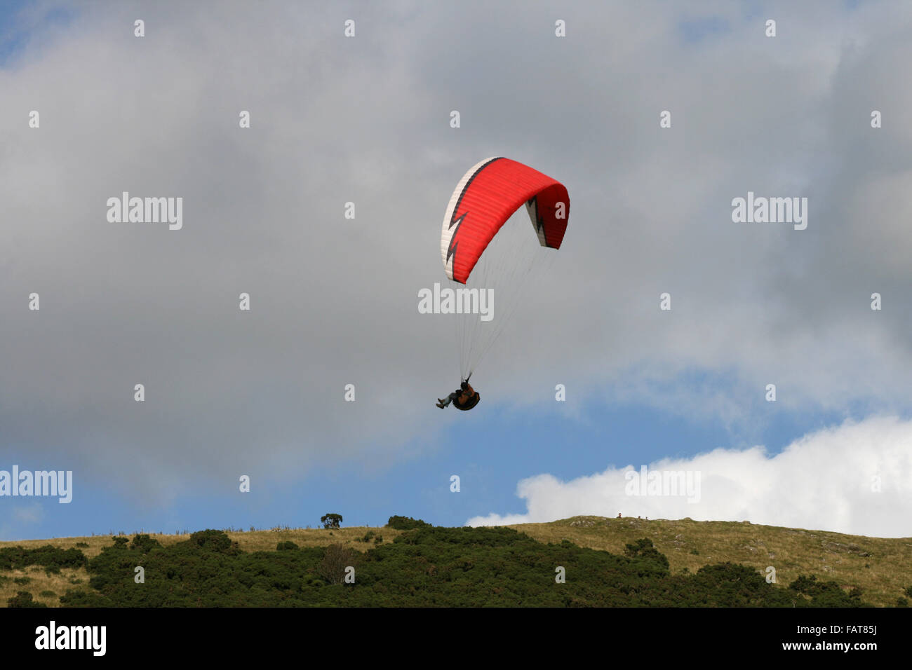 Pilot flying a paraglider against a blue sky perhaps with clouds Stock ...