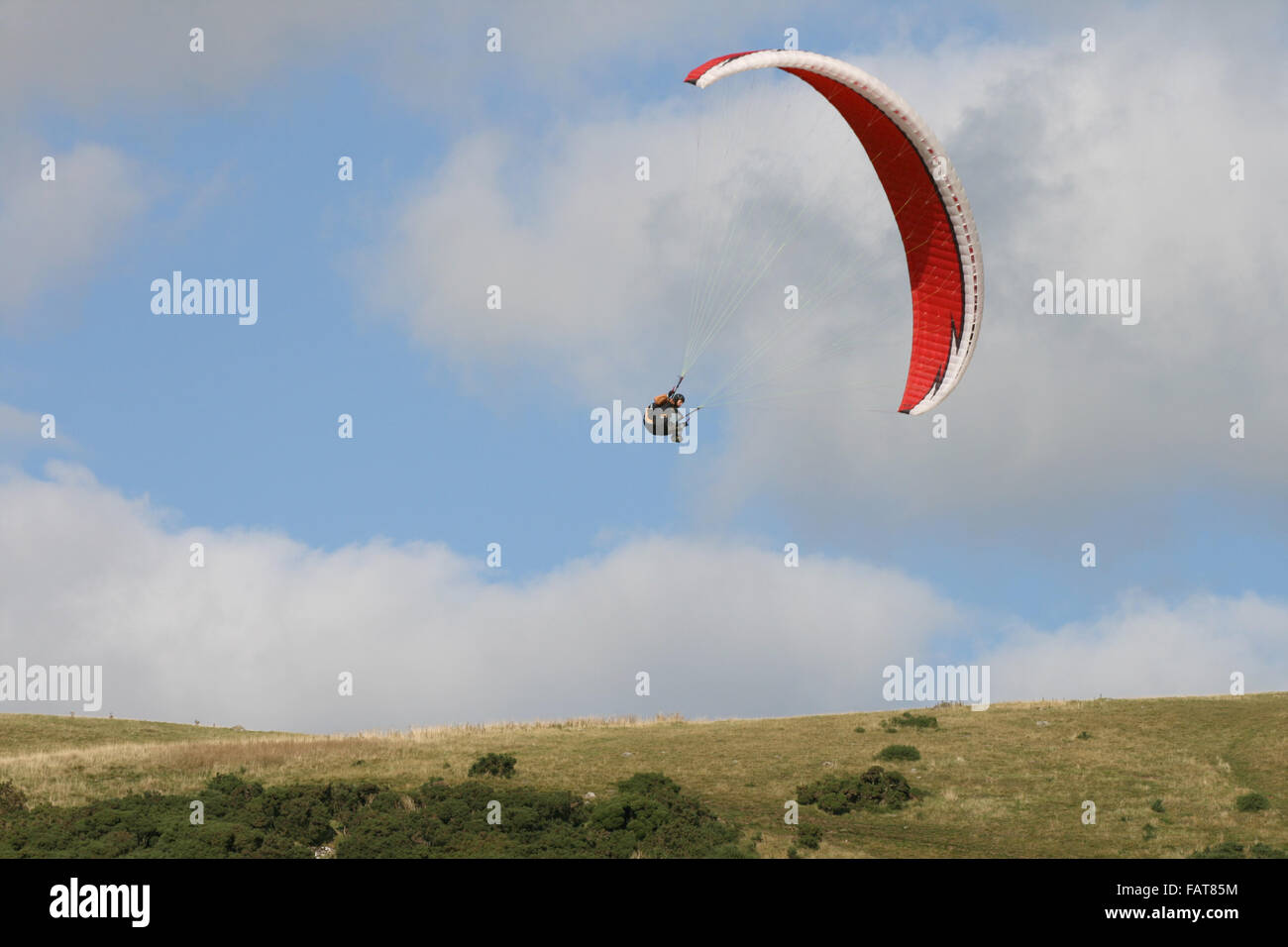 Pilot flying a paraglider against a blue sky perhaps with clouds Stock ...