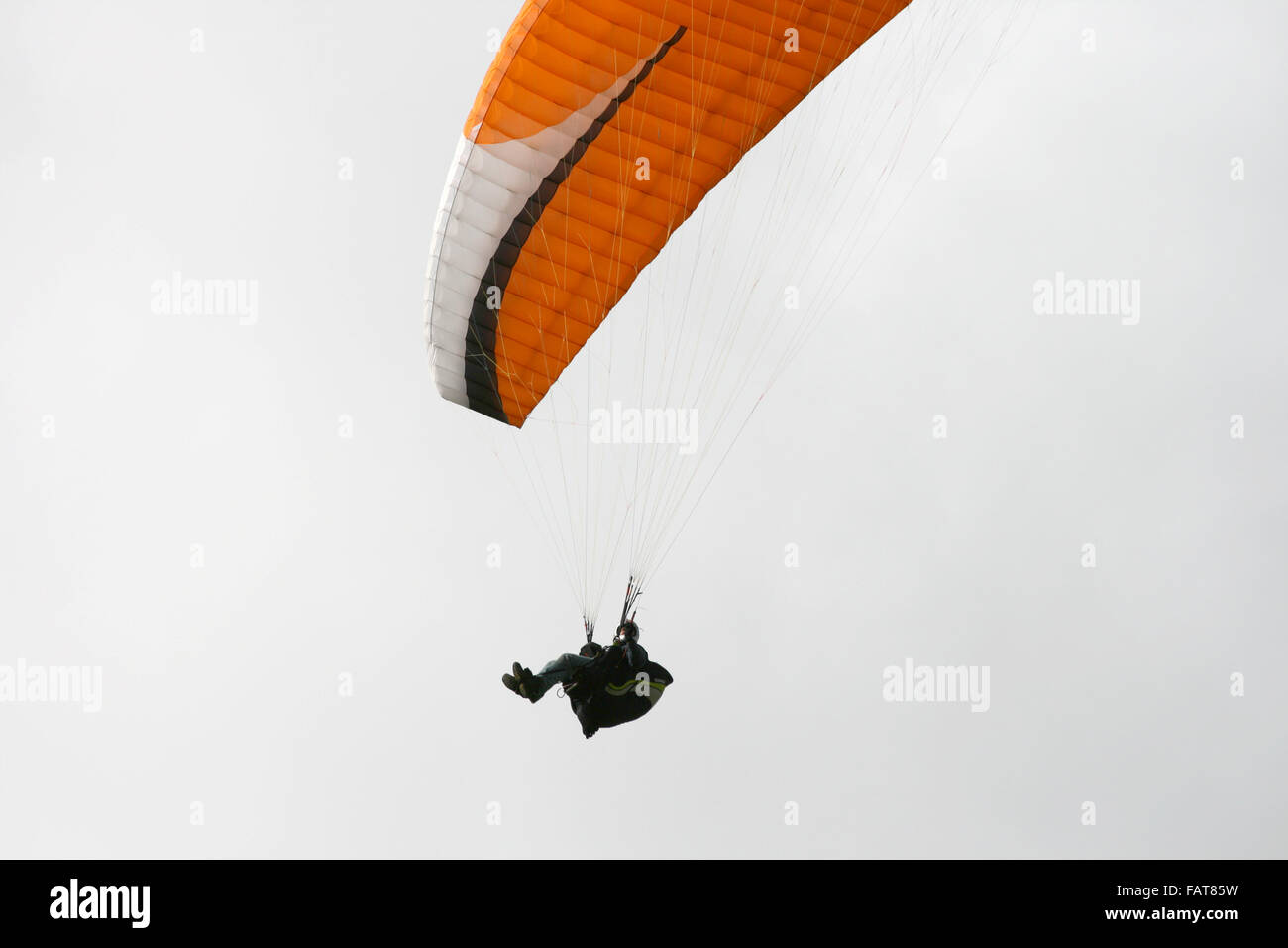 Pilot flying a paraglider against a blue sky perhaps with clouds Stock ...