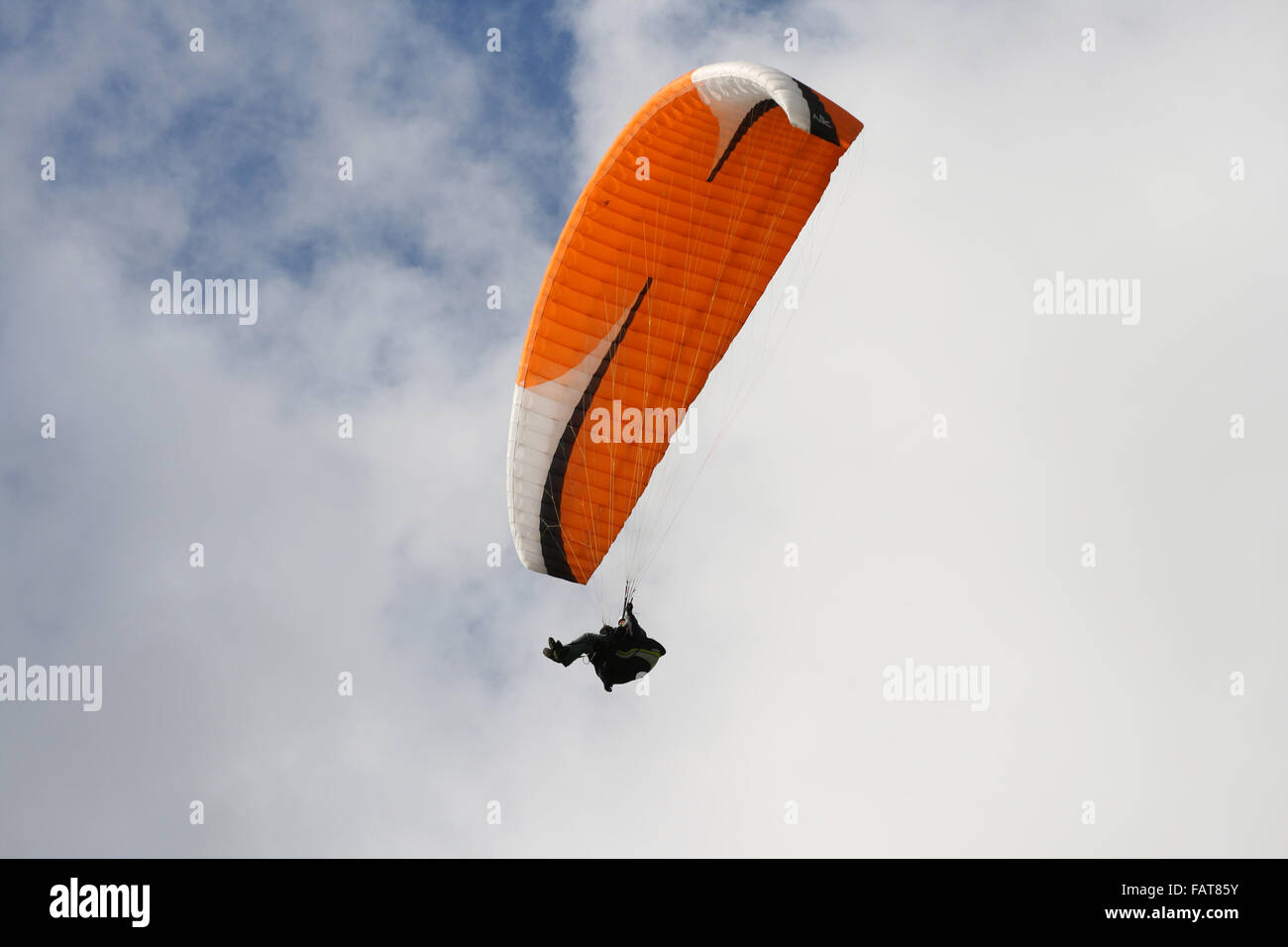 Pilot flying a paraglider against a blue sky perhaps with clouds Stock ...