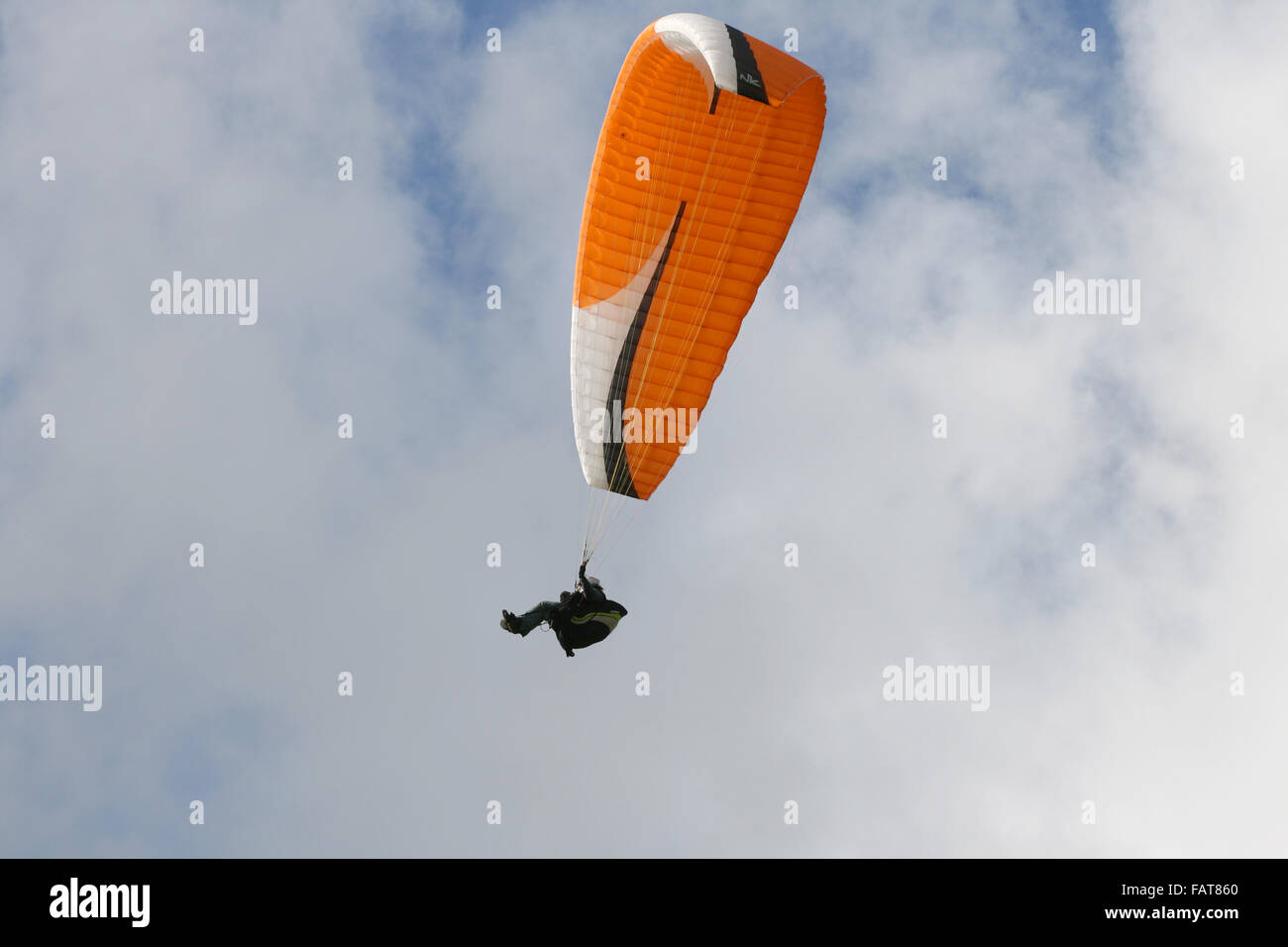 Pilot flying a paraglider against a blue sky perhaps with clouds Stock ...