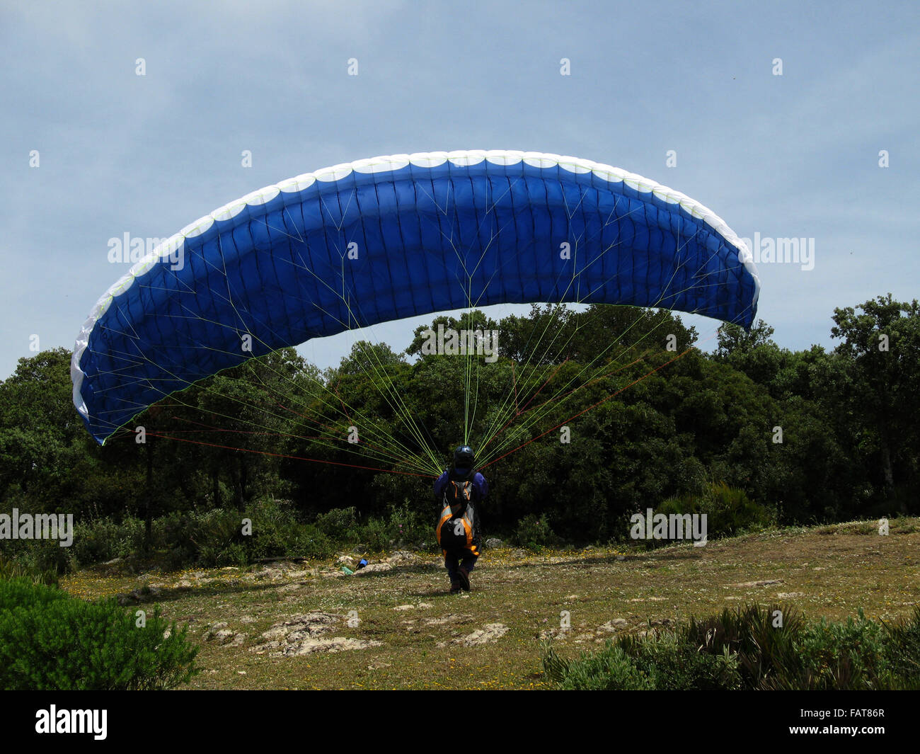 Pilot flying a paraglider against a blue sky perhaps with clouds Stock ...