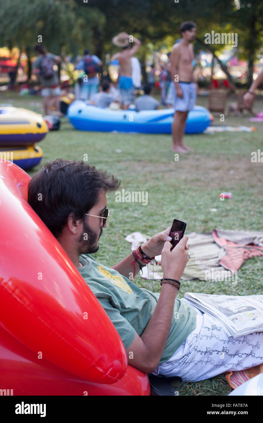 Young man using mobile phone at music festival Stock Photo - Alamy