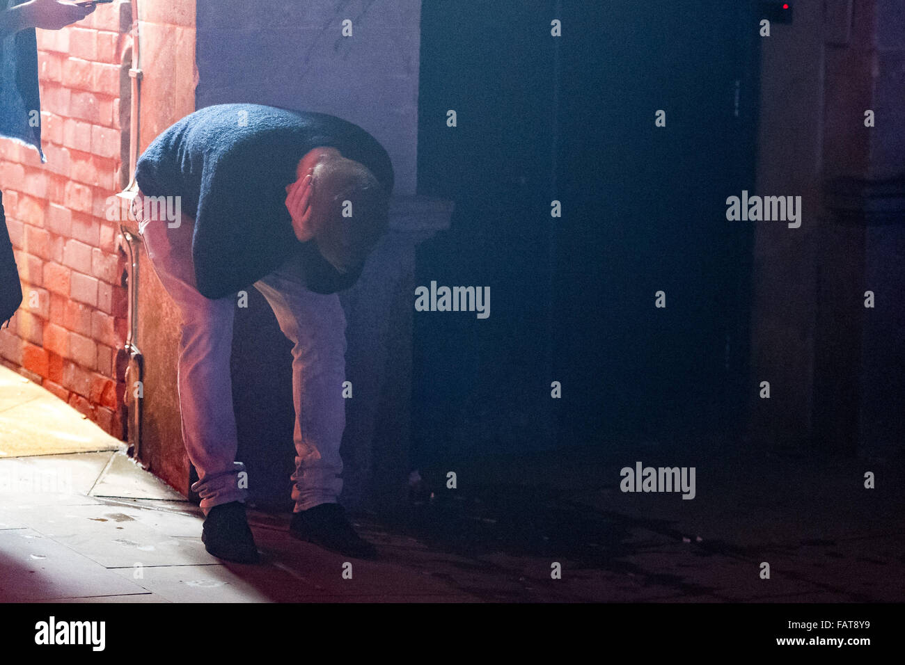 A man slumped against a wall on The Friary Stock Photo - Alamy