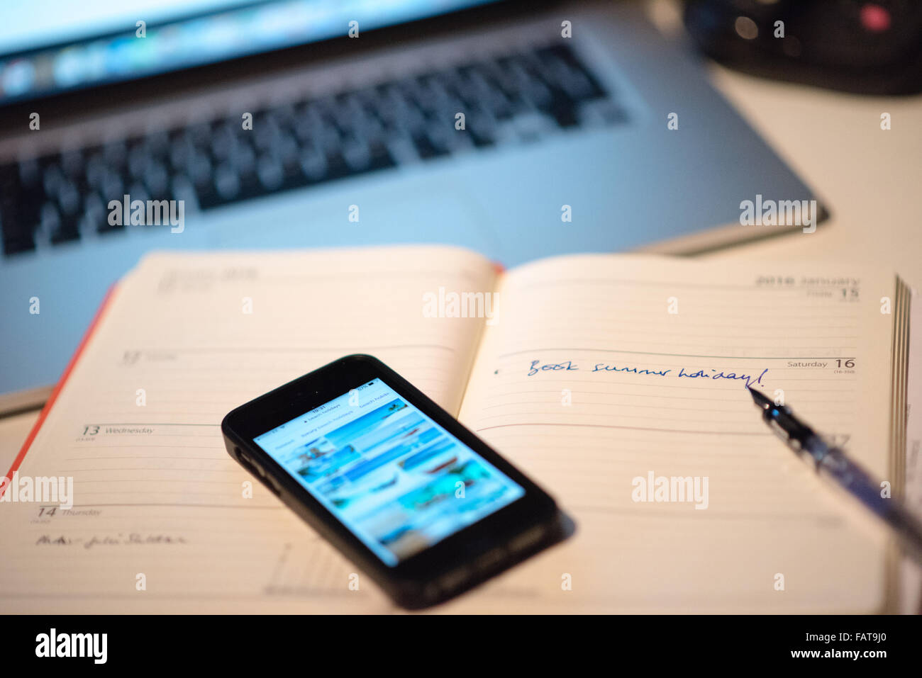 An open diary with the words book summer holiday scribbled on a page ...