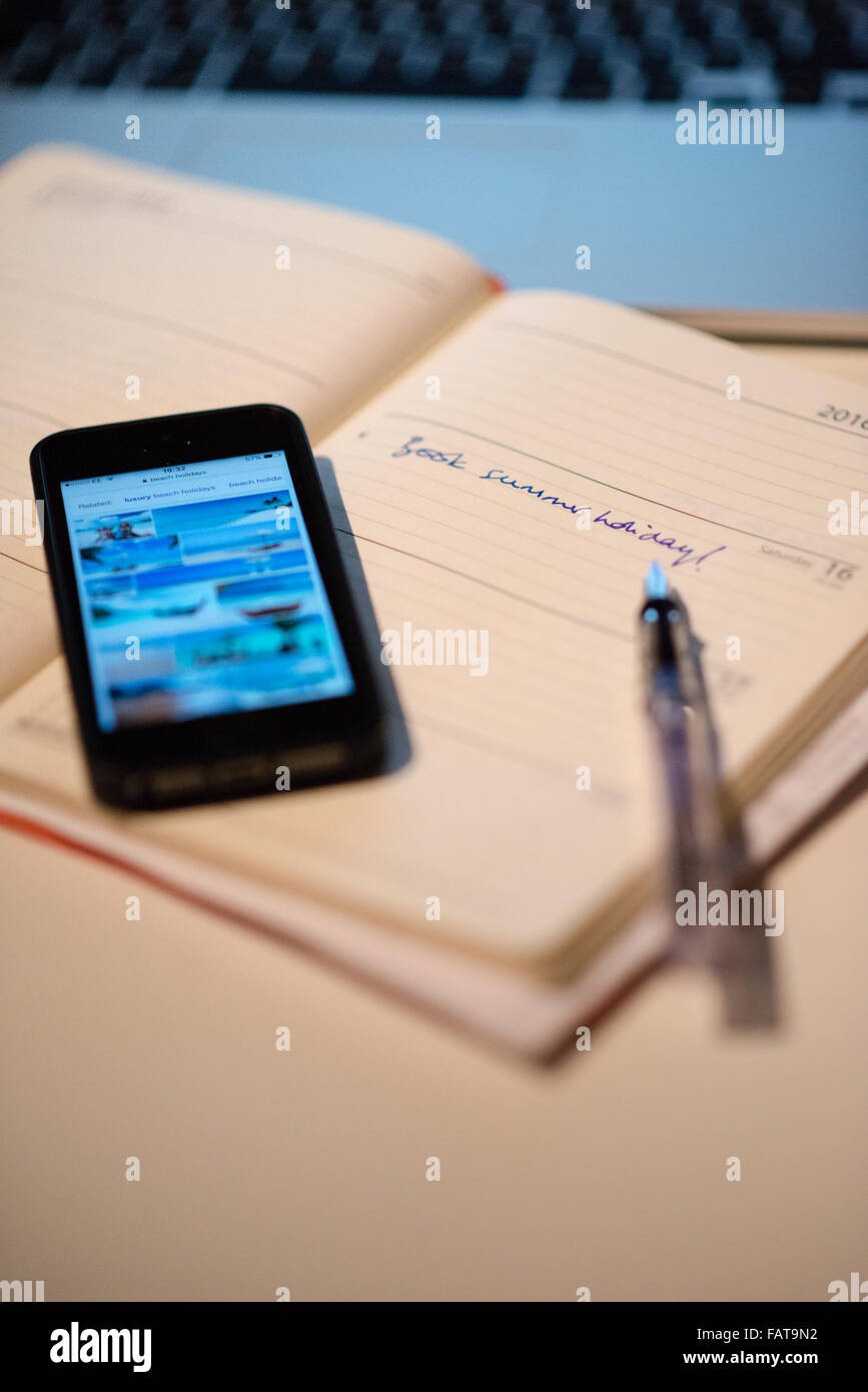 An open diary with the words book summer holiday scribbled on a page ...