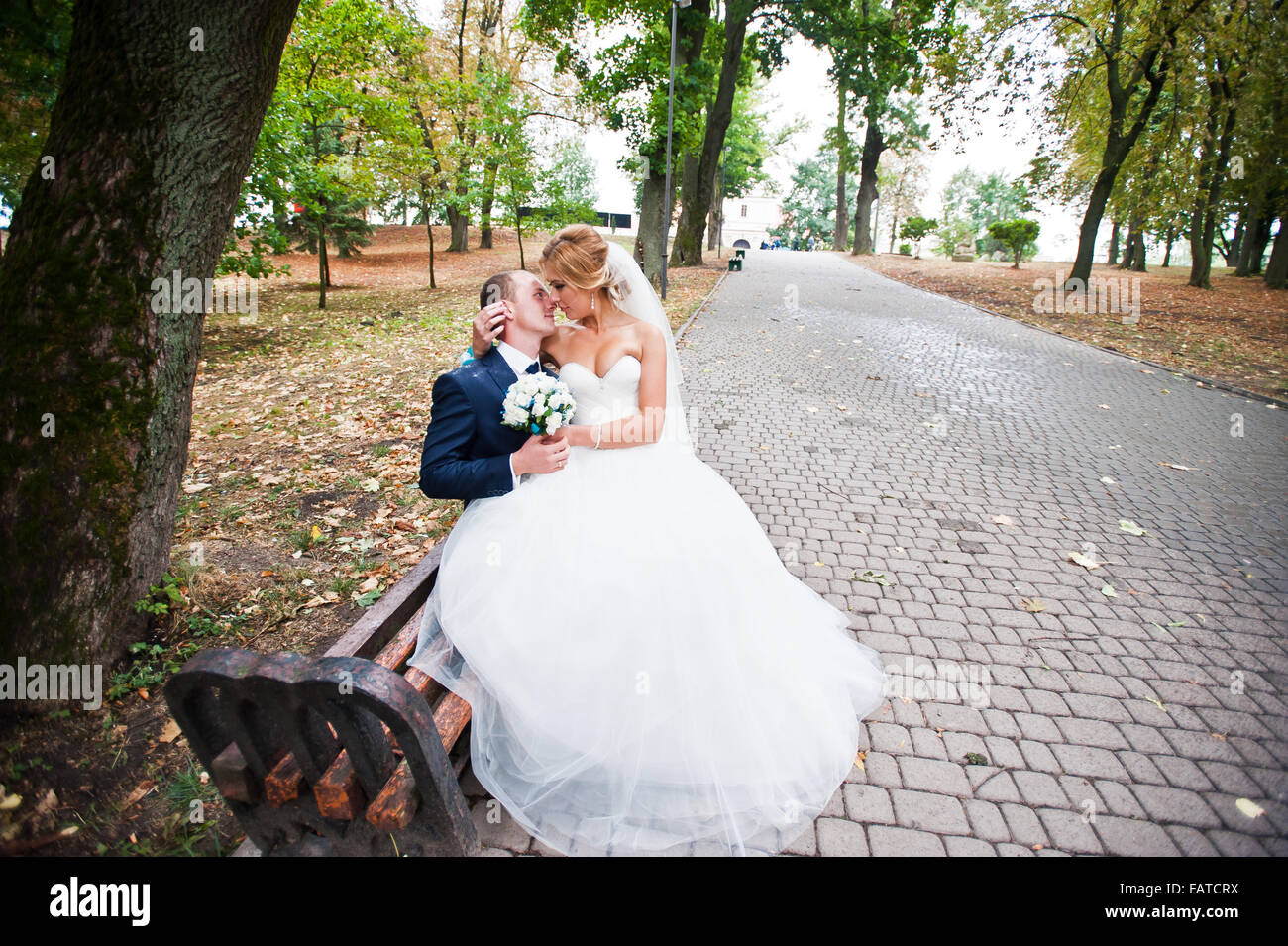 Wedding couple sitting on wooden bench Stock Photo - Alamy