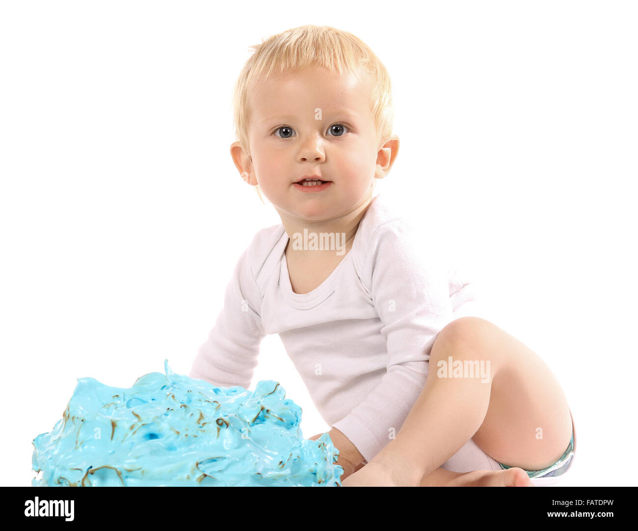 A one year old baby boy smashing a blue iced birthday cake on a wooden ...