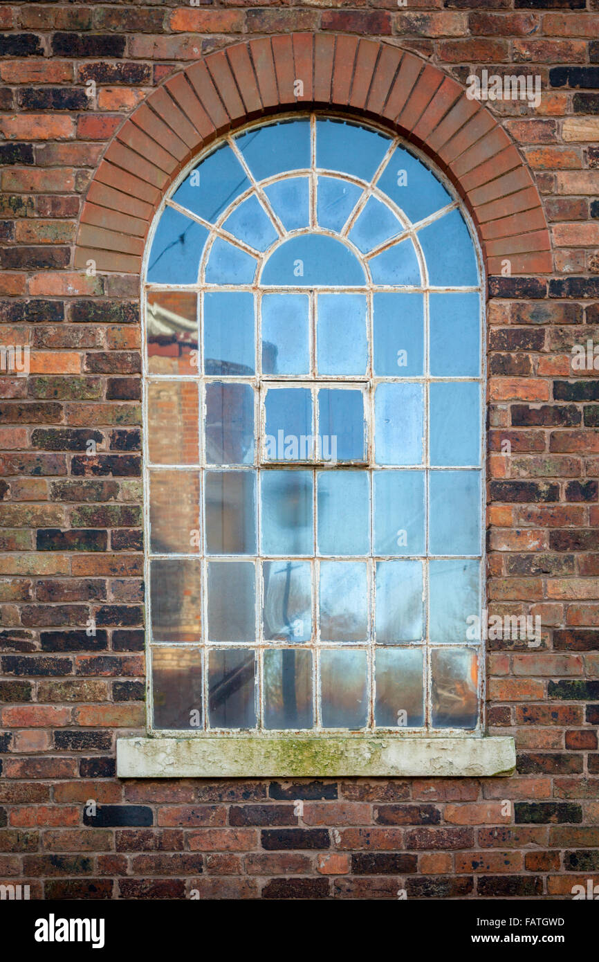 Old fashioned window on an external wall, with iron or metal fixings ...