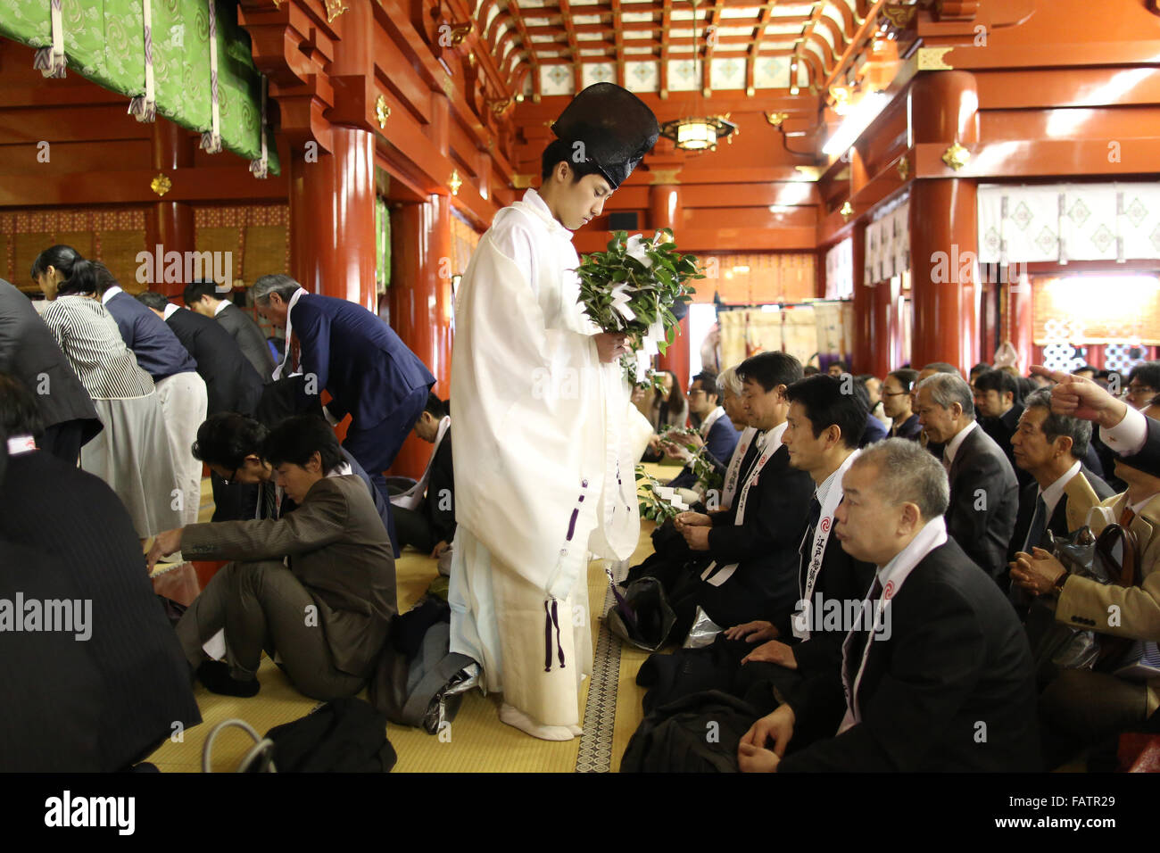 Tokyo, Japan. 4th Jan, 2016. A Shinto priest hands out a sakaki branch ...