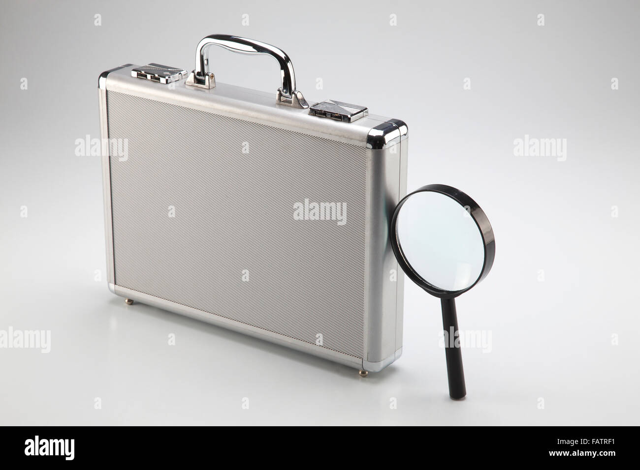 aluminium brief case with the magnifier glass Stock Photo - Alamy