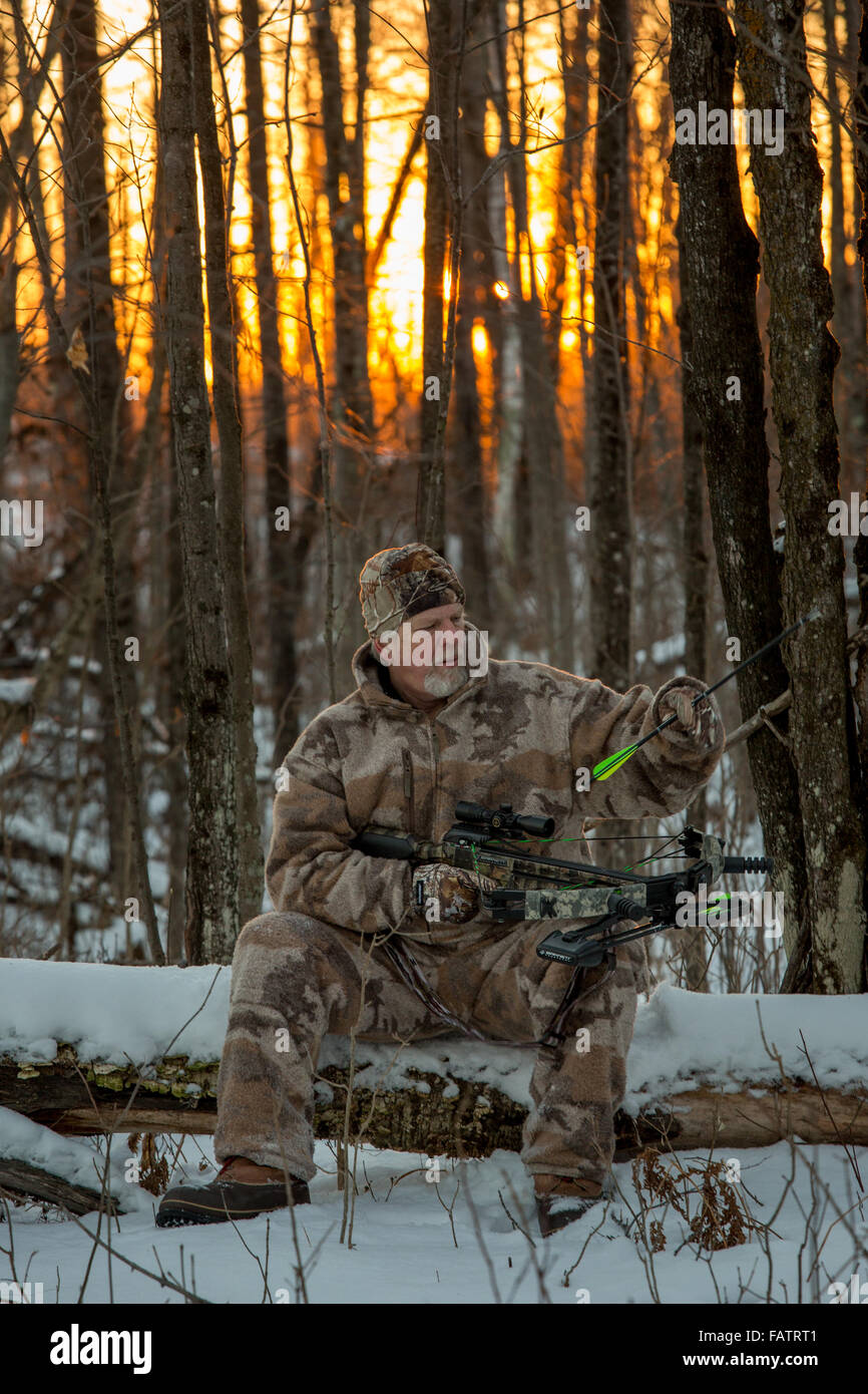 Crossbow hunter sitting on a log Stock Photo - Alamy