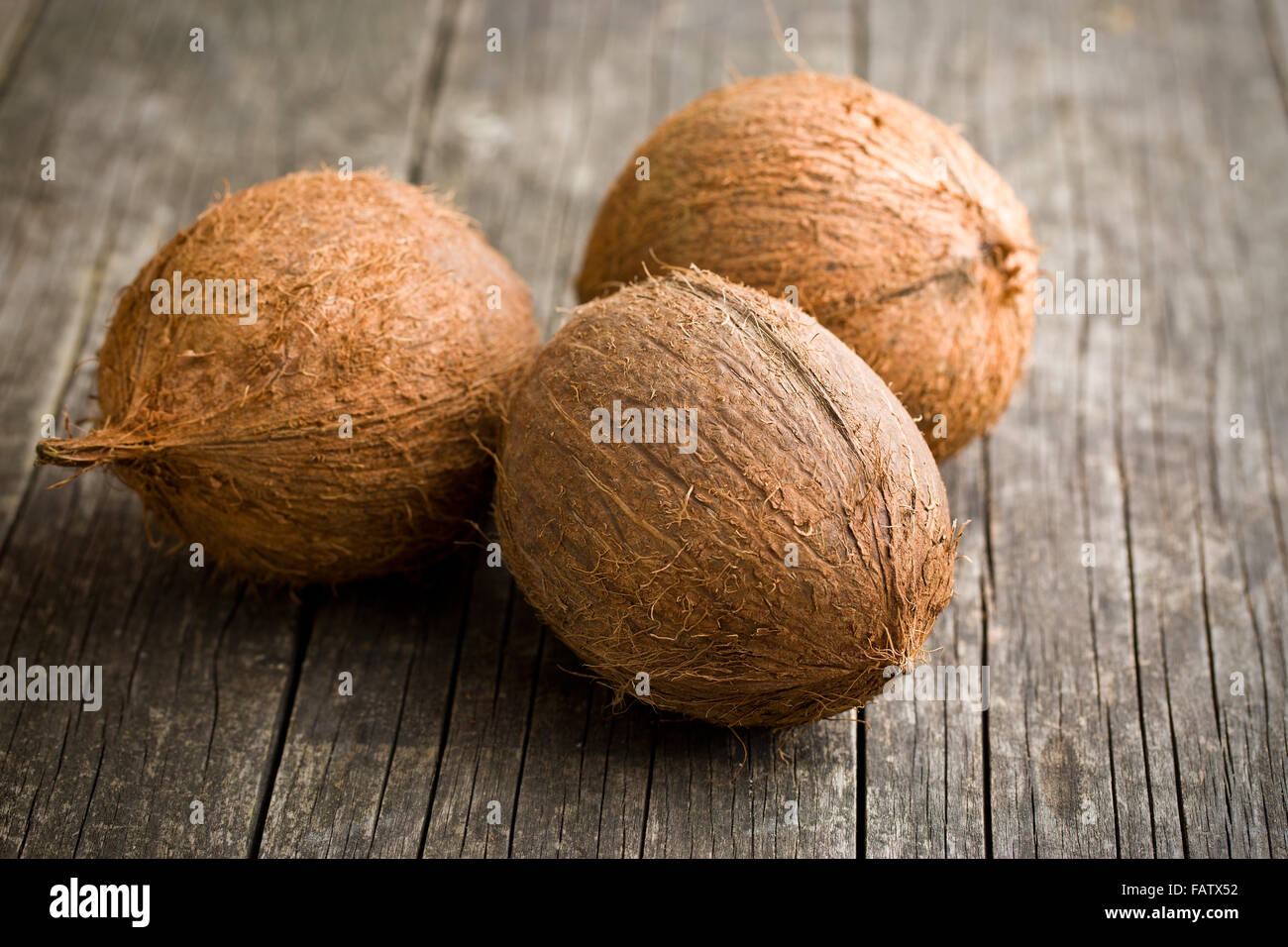 whole coconuts on old wooden table Stock Photo - Alamy