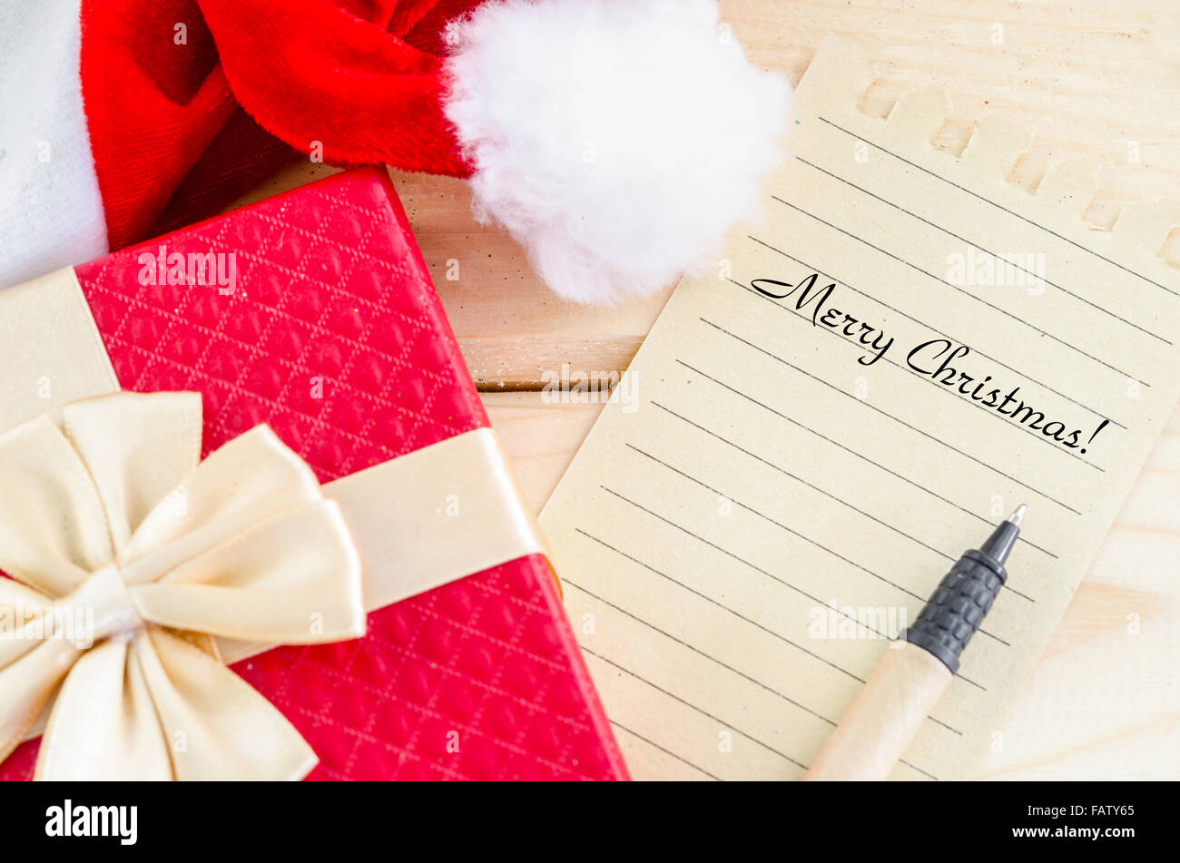 Merry Christmas word writing with pen on brown paper with red gift box ...