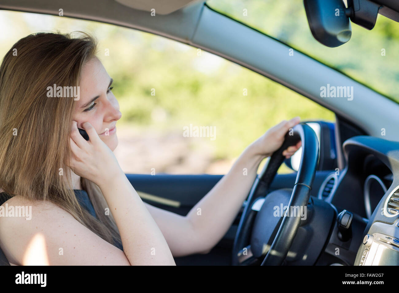Beautiful business woman driving a car, talking on the mobile phone ...