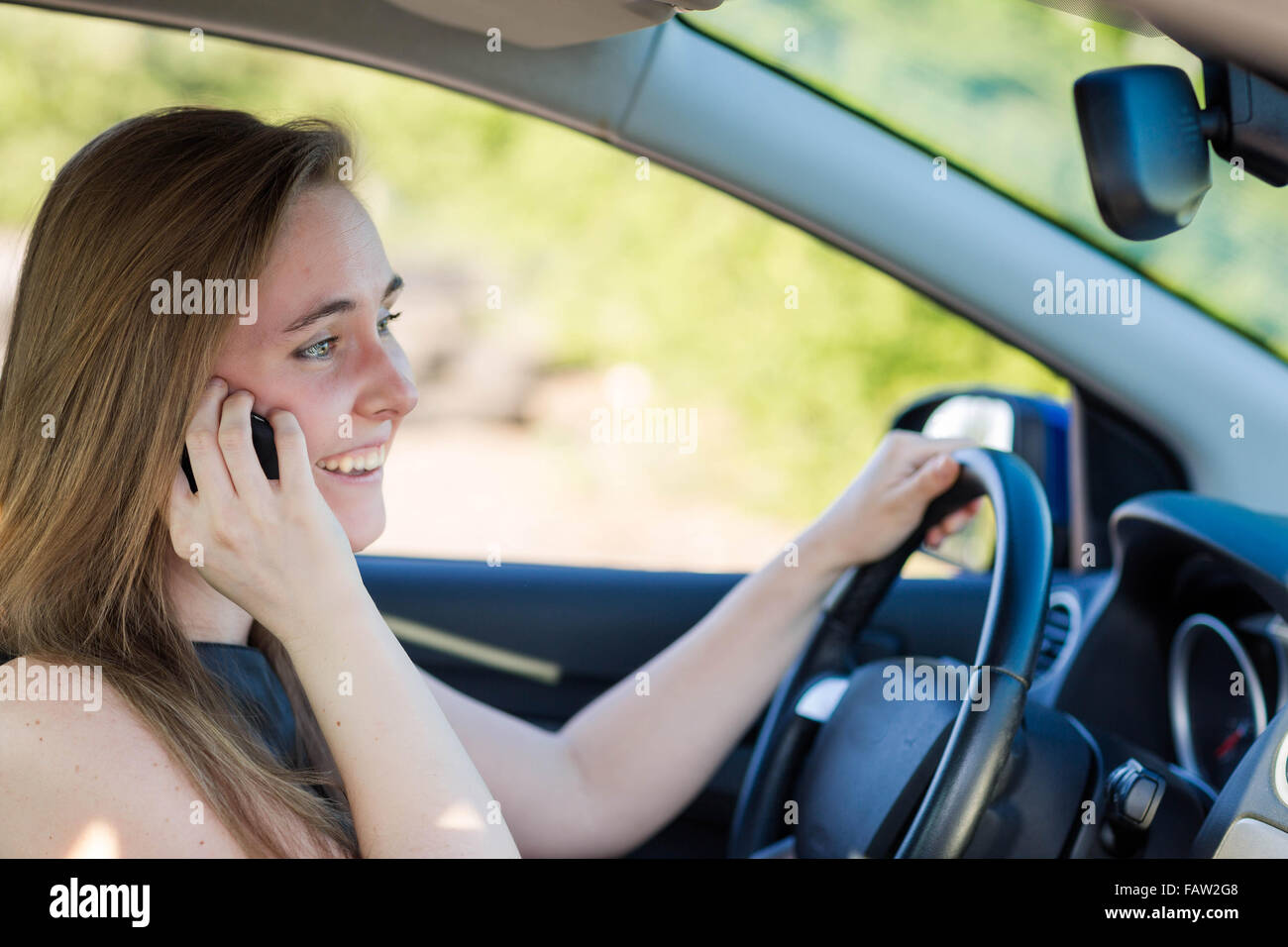 Beautiful business woman driving a car, talking on the mobile phone ...