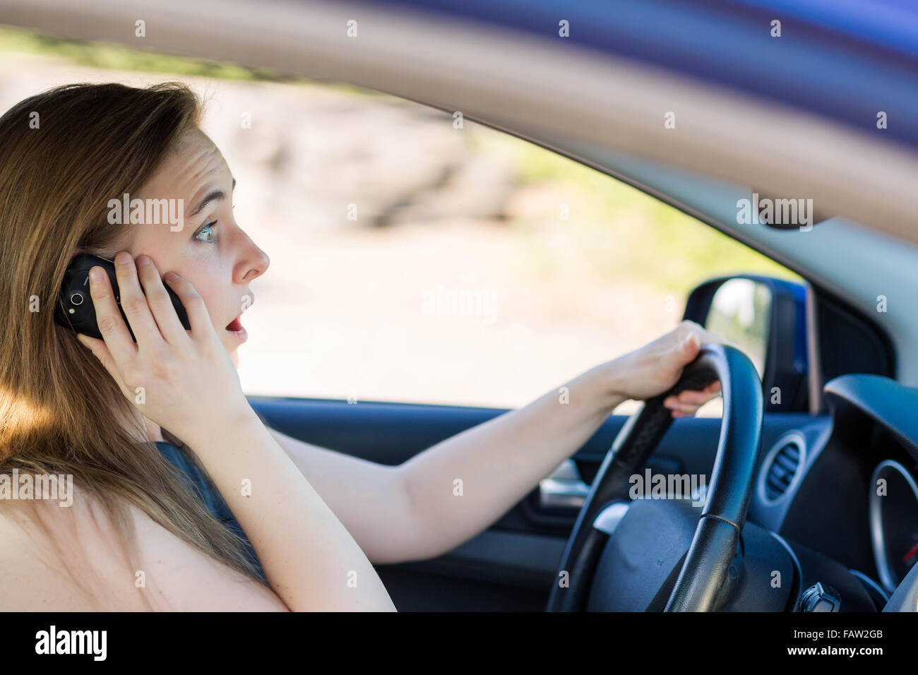 Beautiful business woman driving a car, talking on the mobile phone ...