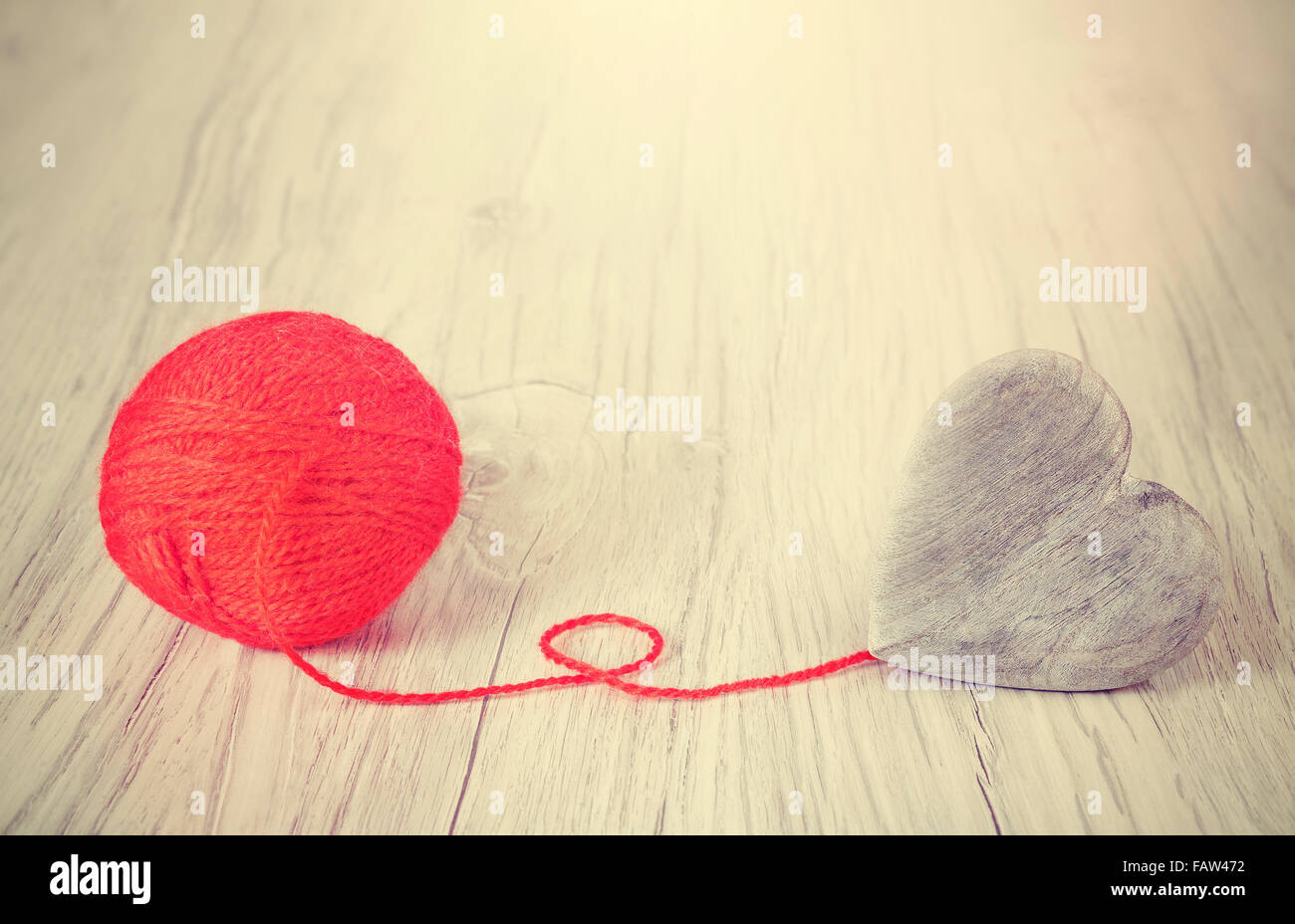 Wooden heart connected to red yarn, concept picture Stock Photo - Alamy
