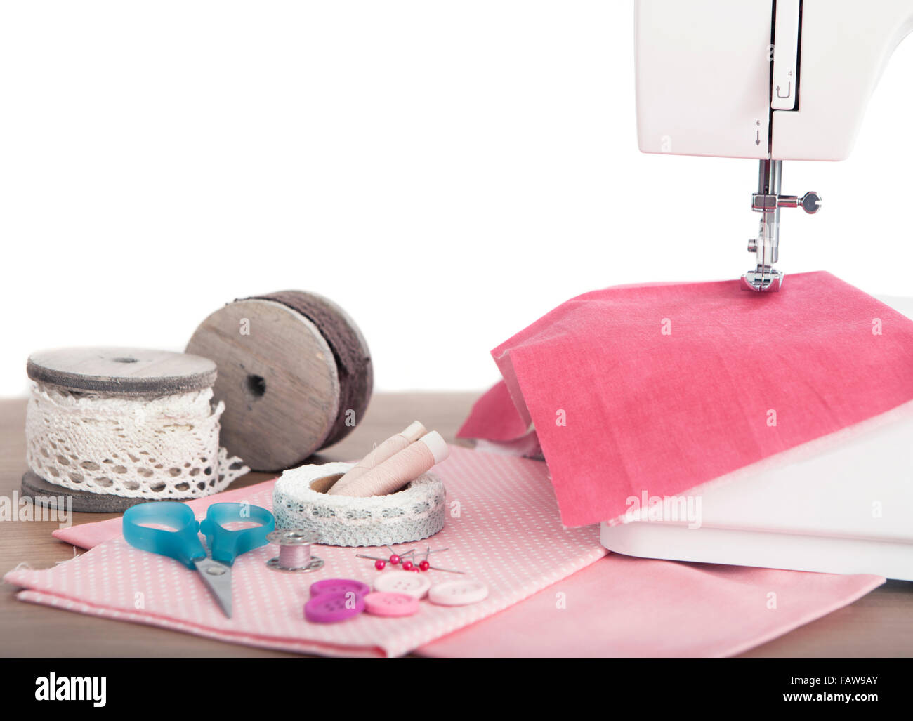 Buttons and needles Sick lie on different fabrics with scissors beside ...