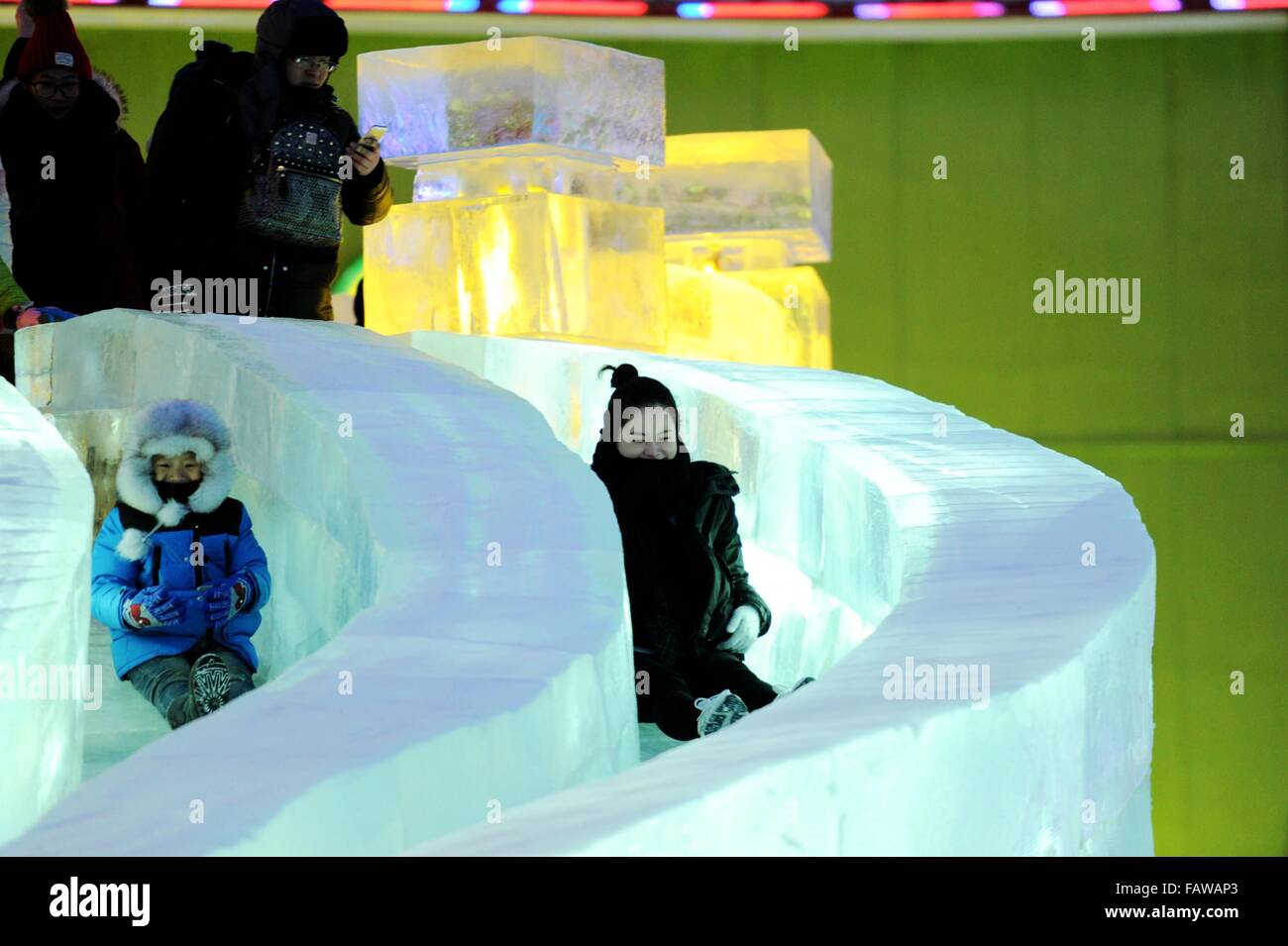 Harbin. 5th Jan, 2016. Tourists have fun on a ice slide as the 32nd ...